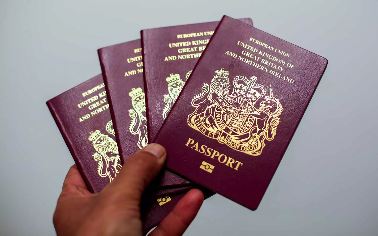 En esta ilustración fotográfica, un hombre tiene 4 pasaportes británicos.