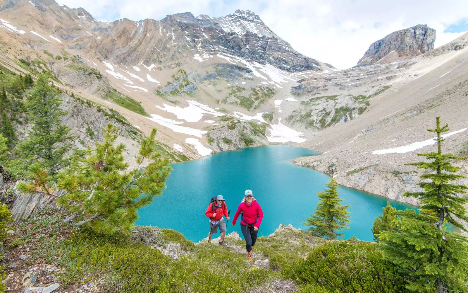 Anthu oyenda m'mapiri amatsatira njira yomwe ili pamwamba pa nyanja yamapiri ku Alberta, Canada