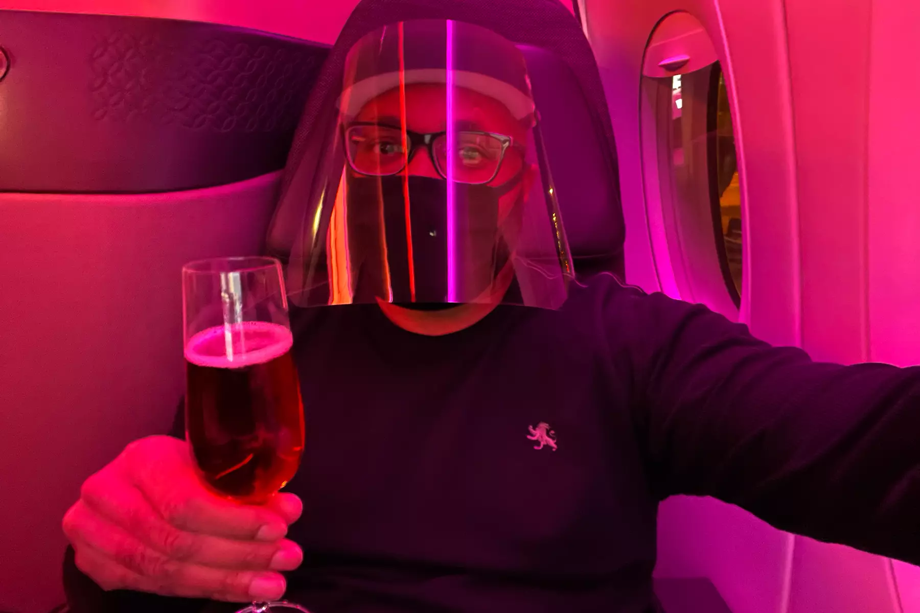 Kwin sa isang Q-Suite onboard na Qatar Airways na nakasuot ng kinakailangang face shield at mask.