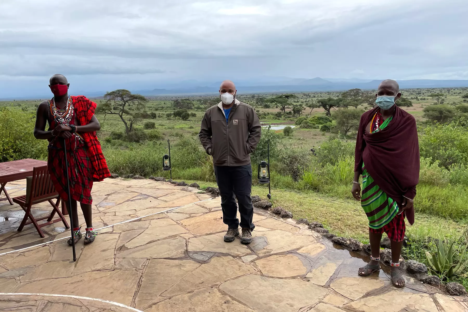 Kwin Mosby sosjaal distânsje mei twa Maasai-mannen by Elewana Tortilis Camp Amboseli.