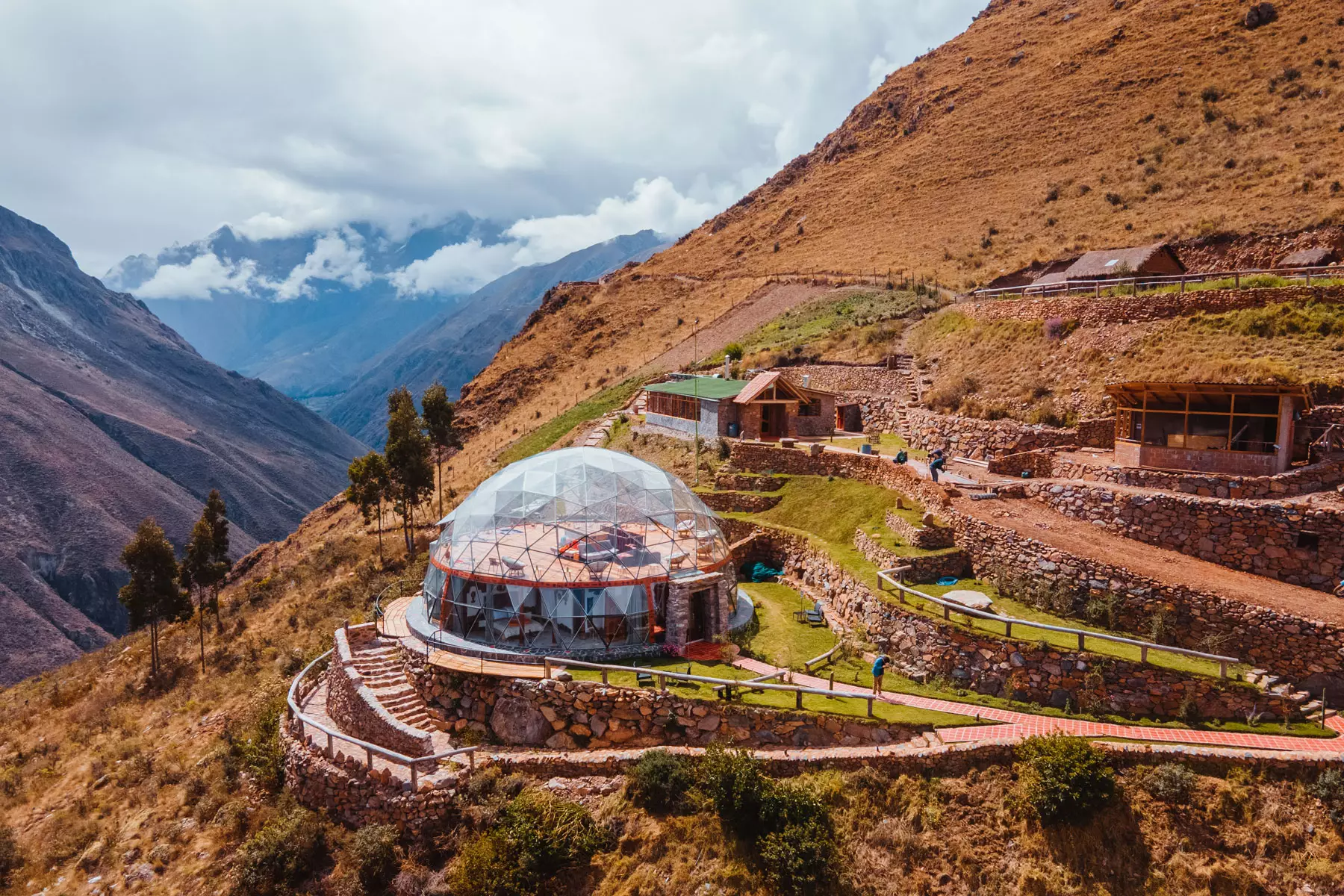 Luxusní butikový hotel s jasnou kupolovou strukturou uhnízděný v horách Peru. Panoramatický výhled z pokoje pro hosty a restaurace