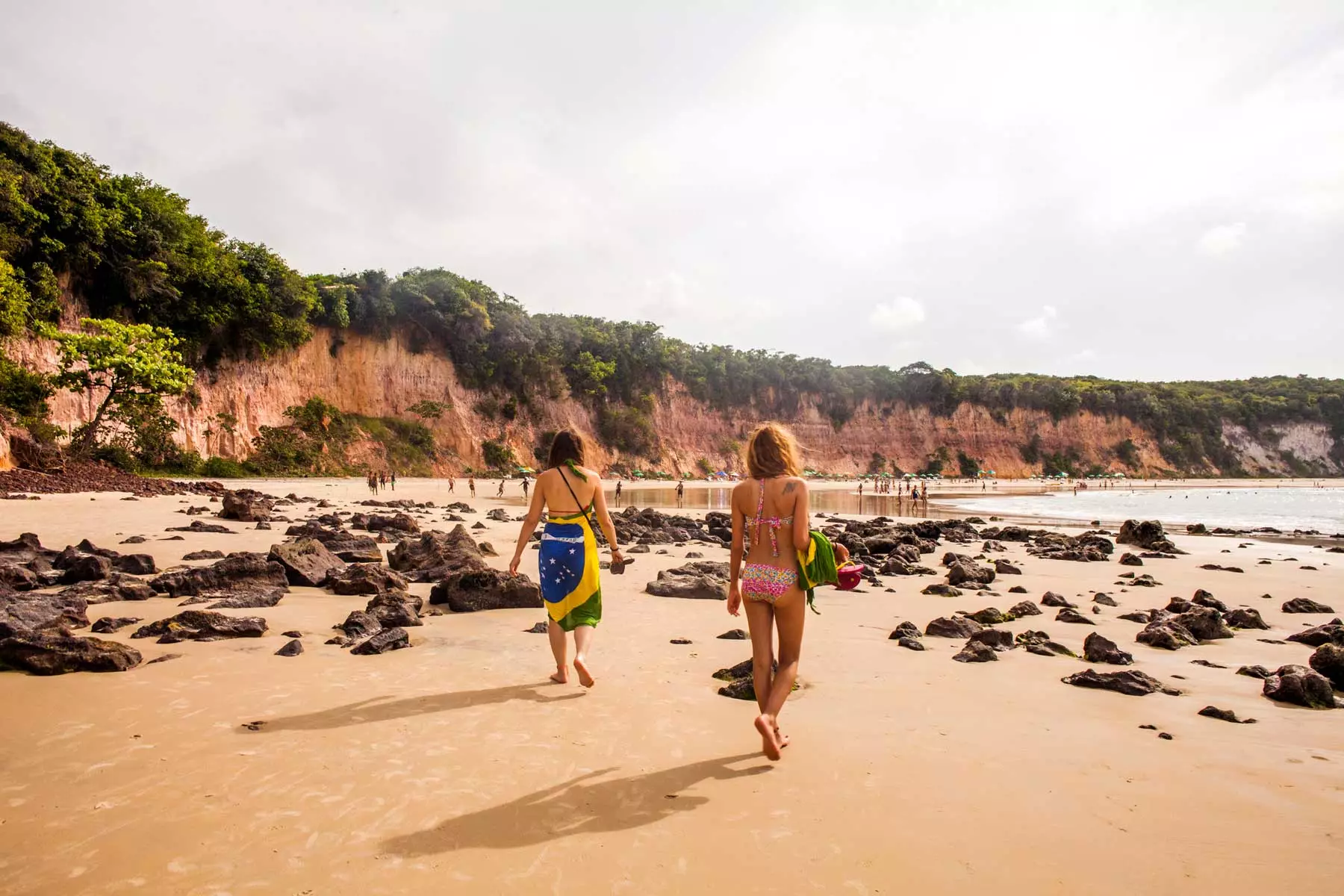 Un groupe de personnes marchant sur Praia de Pipa au Brésil.