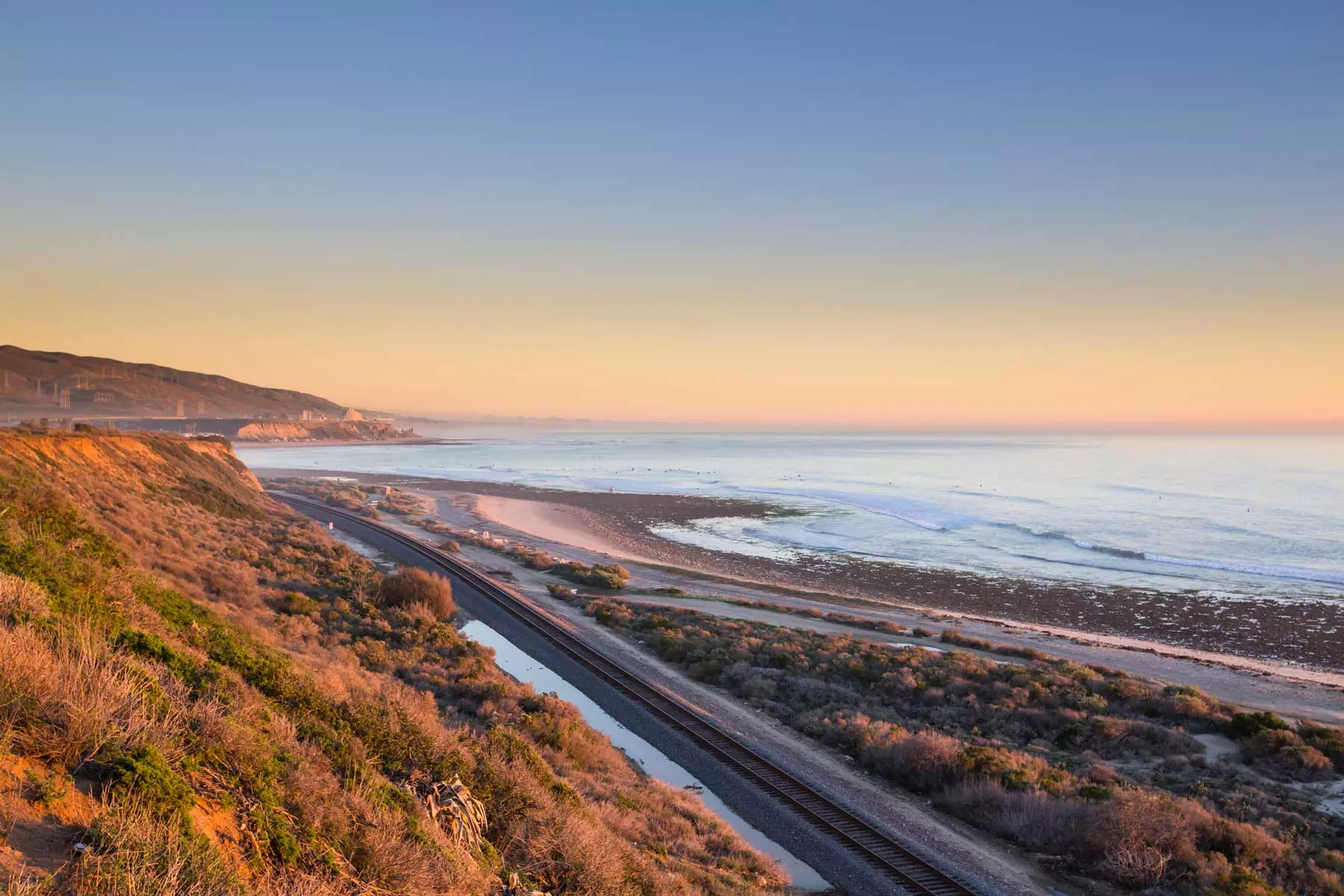 En Californie, les surfeurs profitent d'un magnifique coucher de soleil hivernal tout en surfant sur les vagues.