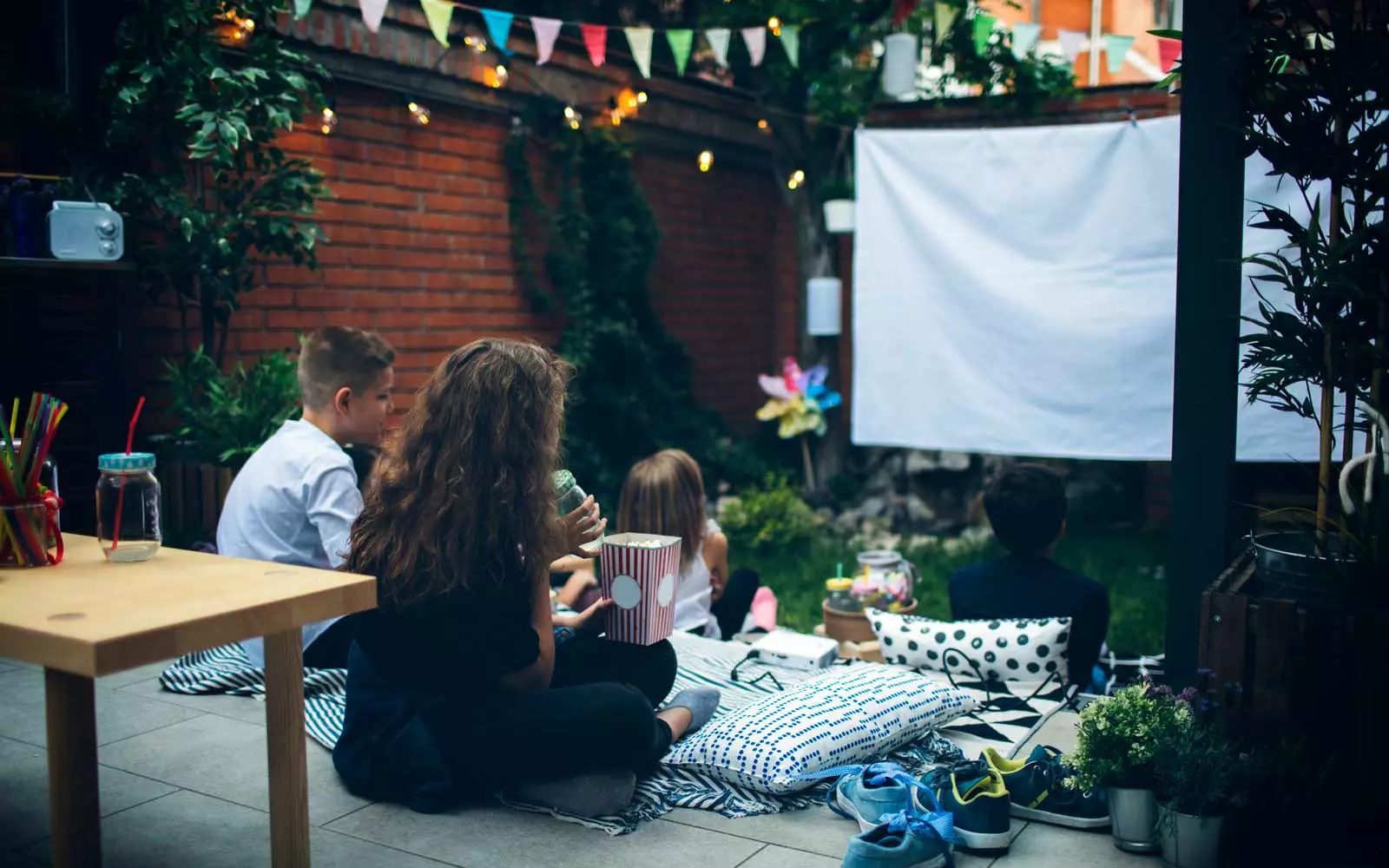 Geschwister schauen sich im Garten einen Film an