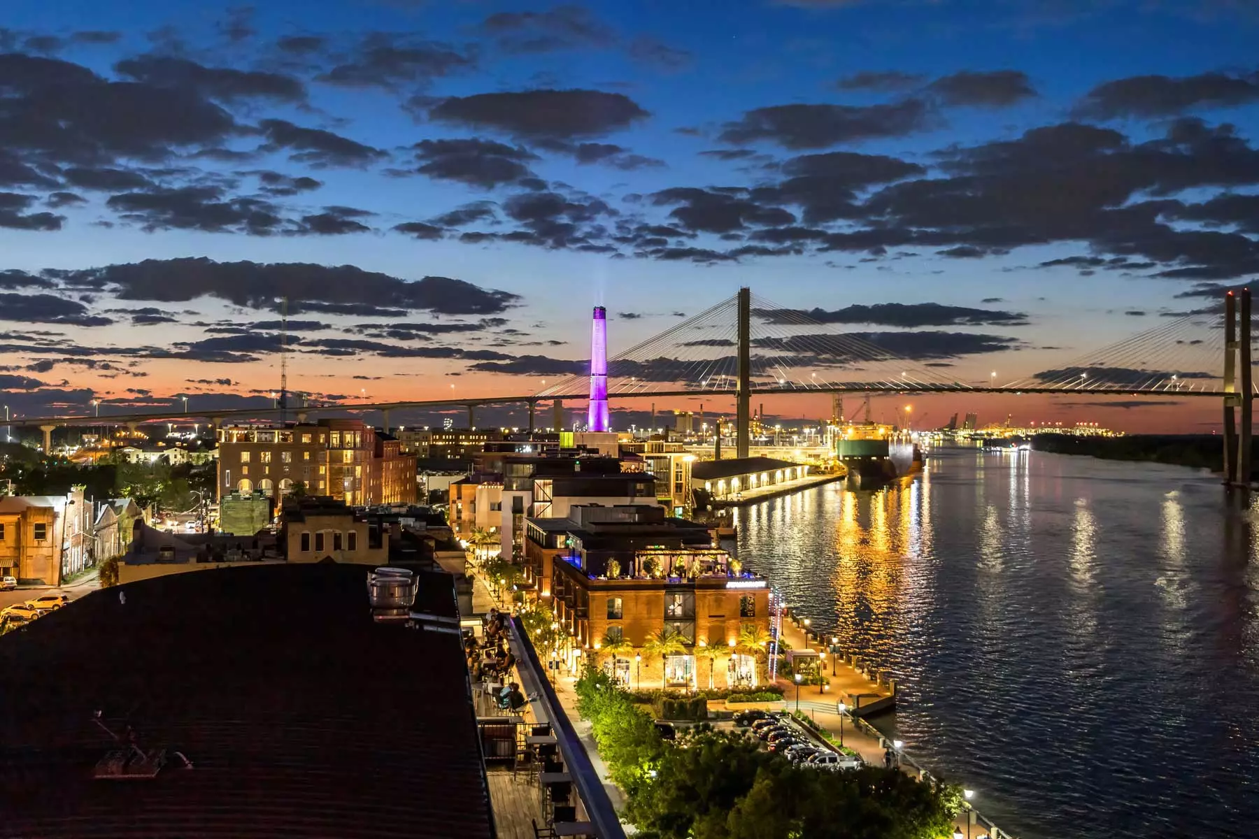 Panorama Savannah Georgia o zmierzchu ze szczytu dachu z wodą rzeki, mostem i budynkami