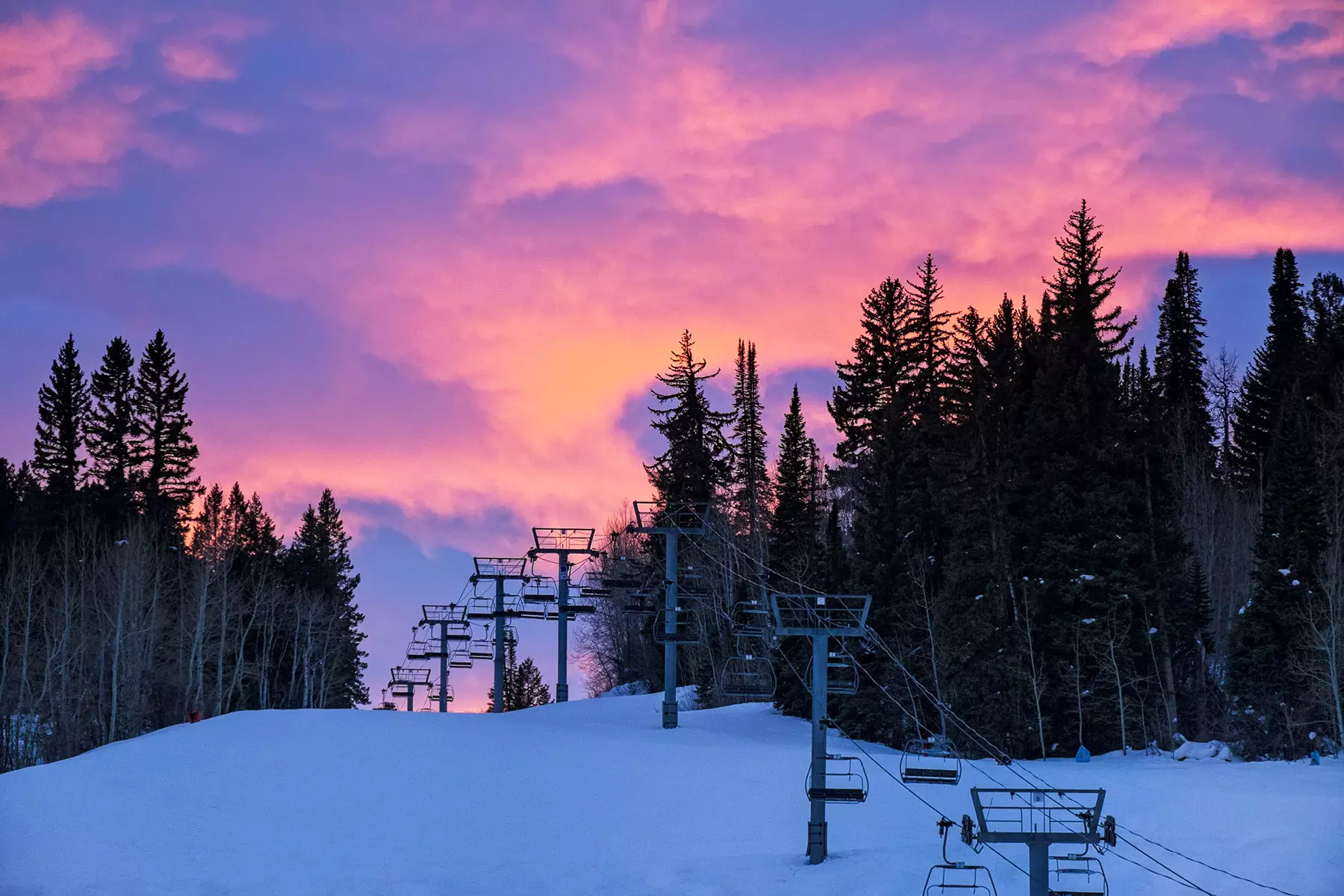 Rêzên Skî li Sunset bi Ewrên Pembe yên Dramatîk li ser Buttermilk Mt.