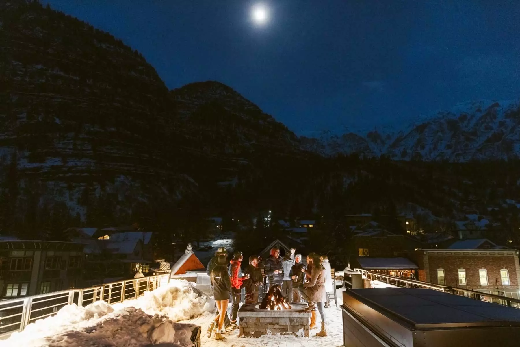 Lidé se v zimě shromažďují kolem ohniště na střeše hotelu Imogene v Ouray, CO