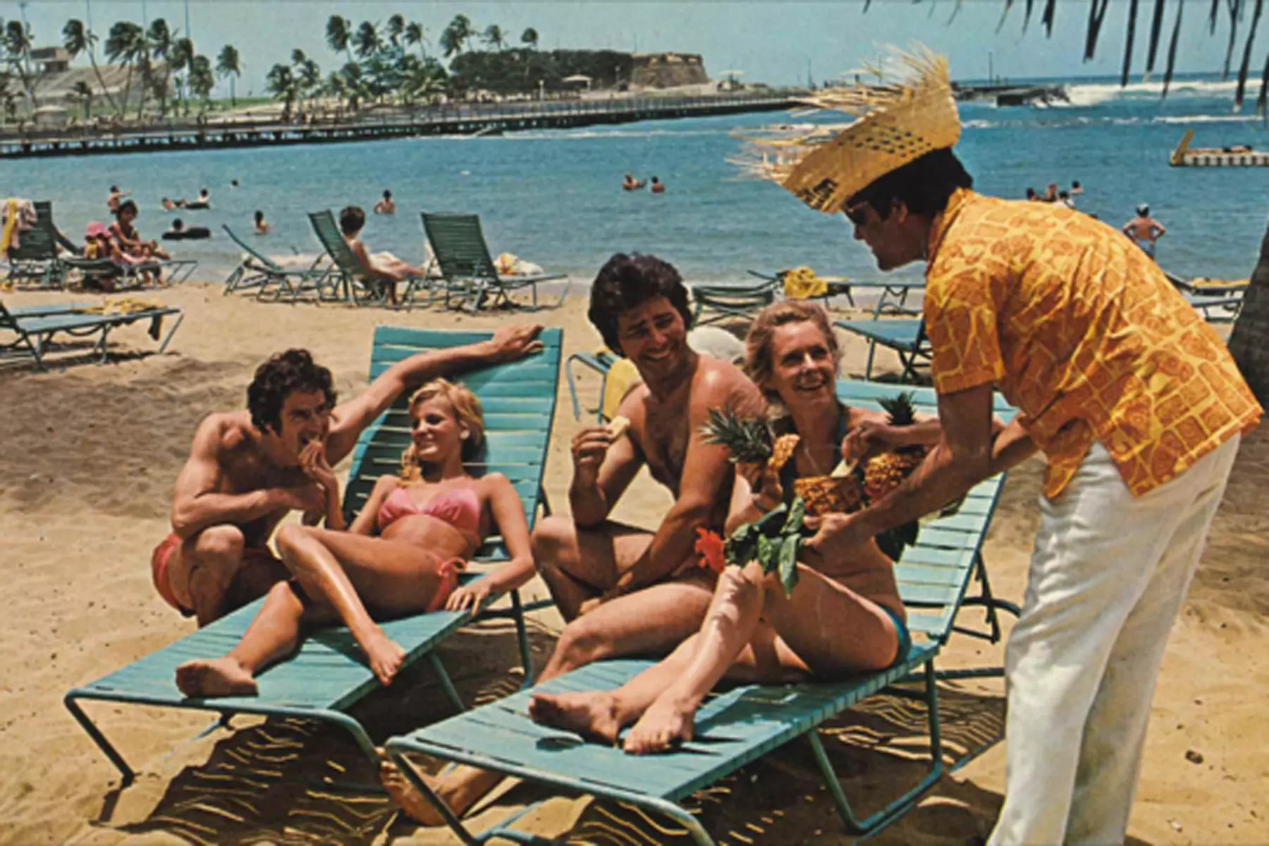 Vintage fotó a Puerto Ricó-i Caribe Hilton vendégeiről, akik Piña coladákat élveznek a tengerparton