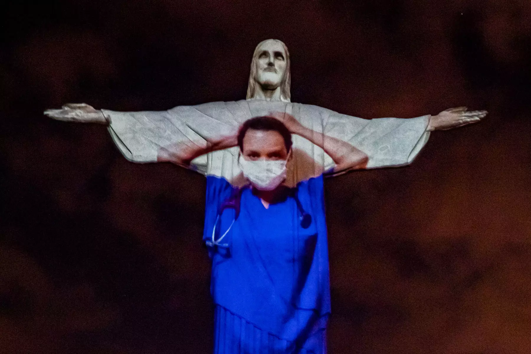 Egy egészségügyi dolgozó képe a Megváltó Krisztus kivilágított szobrán