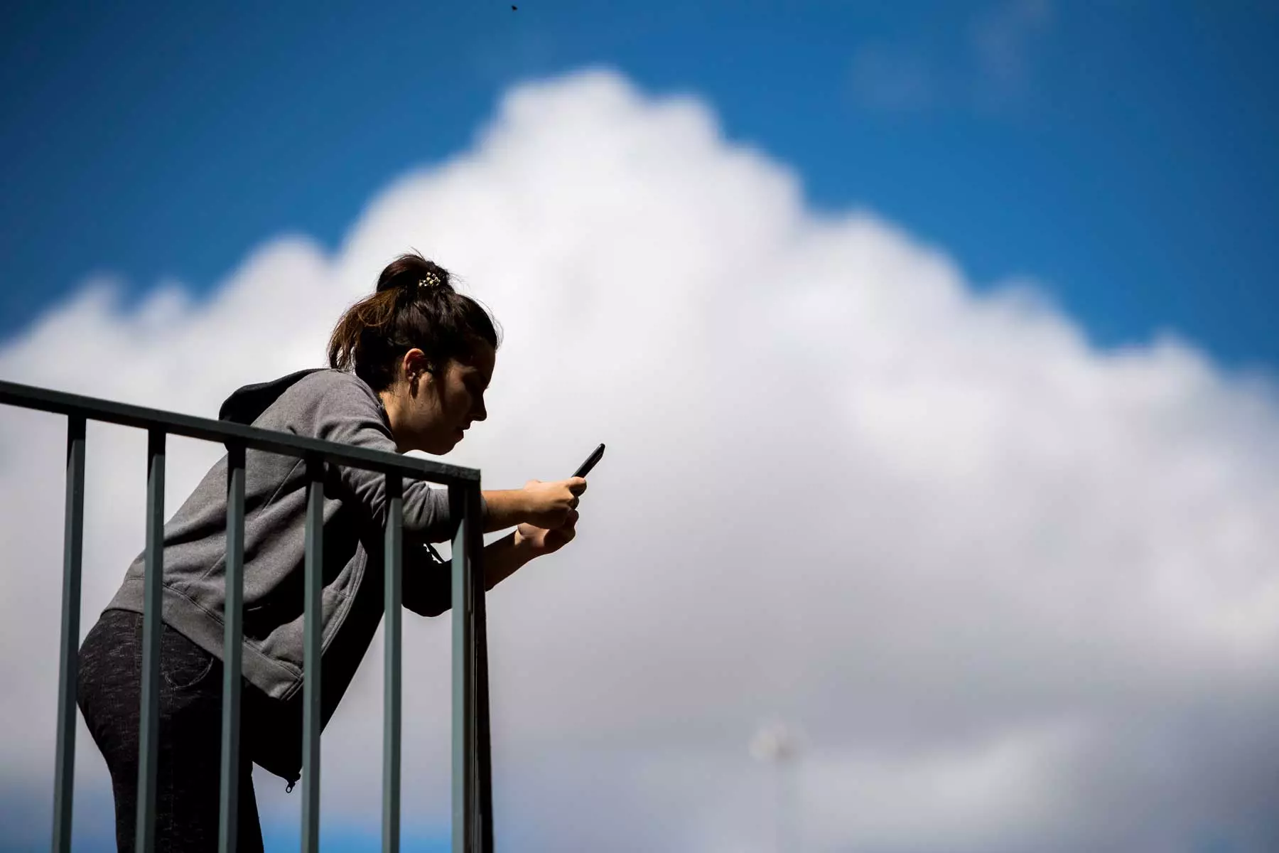 O se fafine o loʻo faʻaogaina lana telefoni i luga o le poletito o lona fale