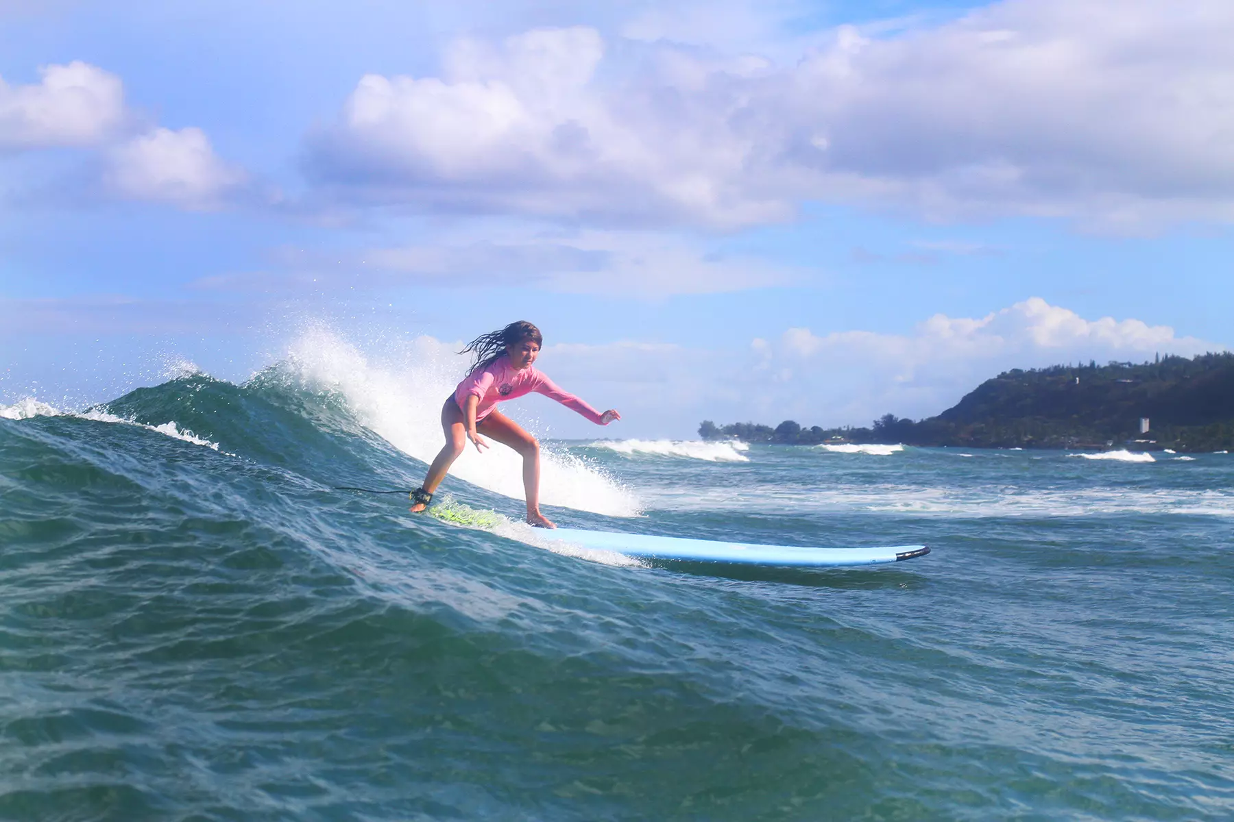 Cailín beag ag scimeáil le North Shore Surf Girls