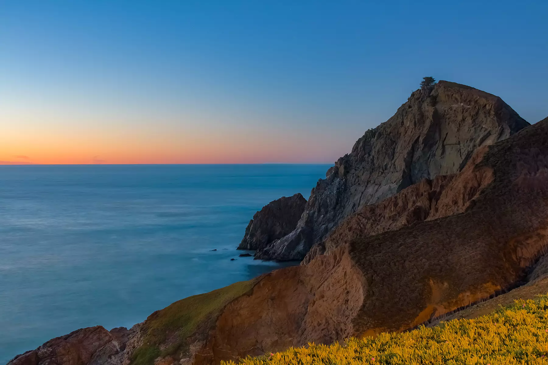 Dhagaxyo dhaadheer oo xeebaha ah oo ku yaal jidka Shaydaanka ee California markay qorraxdu dhacdo iyo badweynta xariirta ah ee ka imanaysa soo-gaadhista dheer