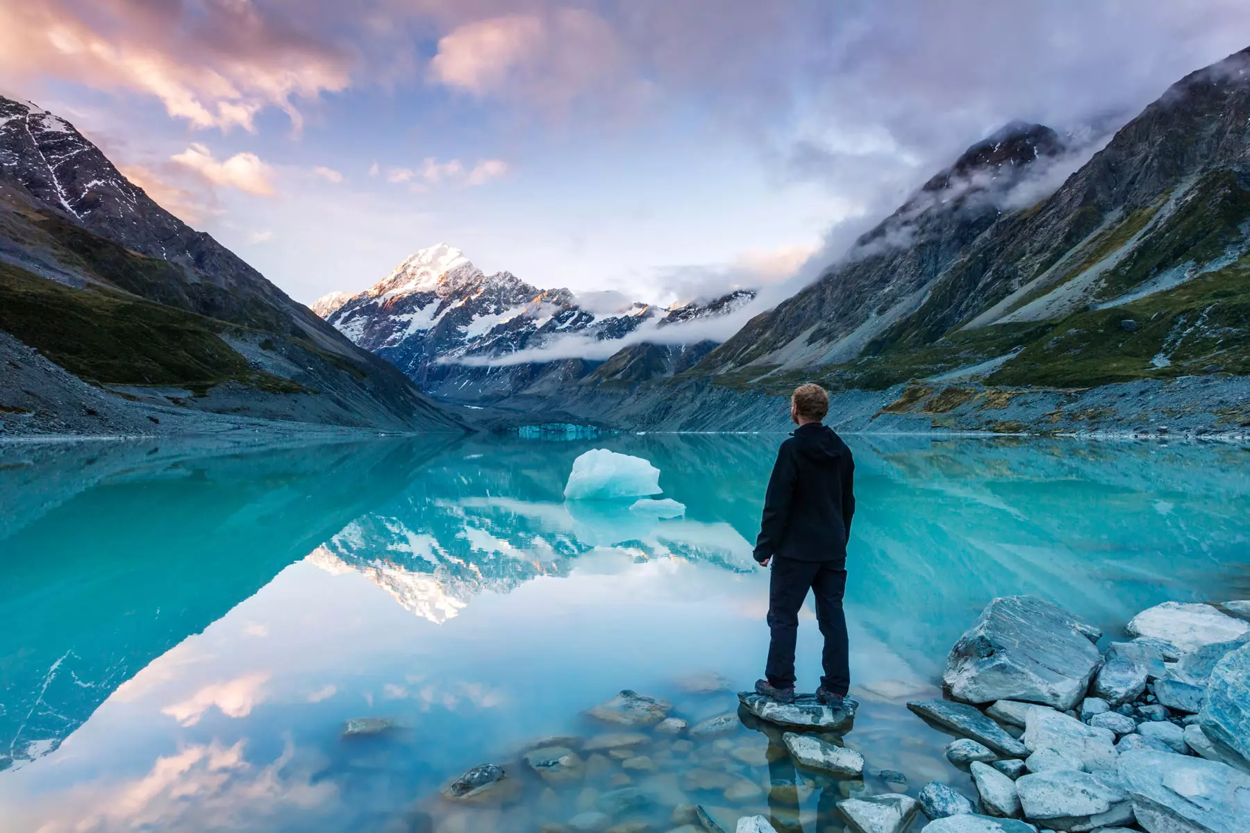 Man wat voor Mount Cook in Nieu-Seeland staan