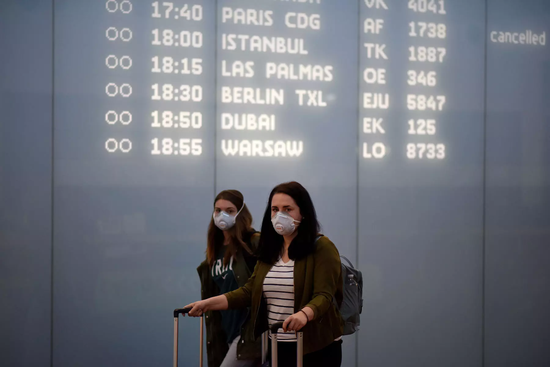 passazjiers mei beskermjende maskers komme oan op Wenen International Airport