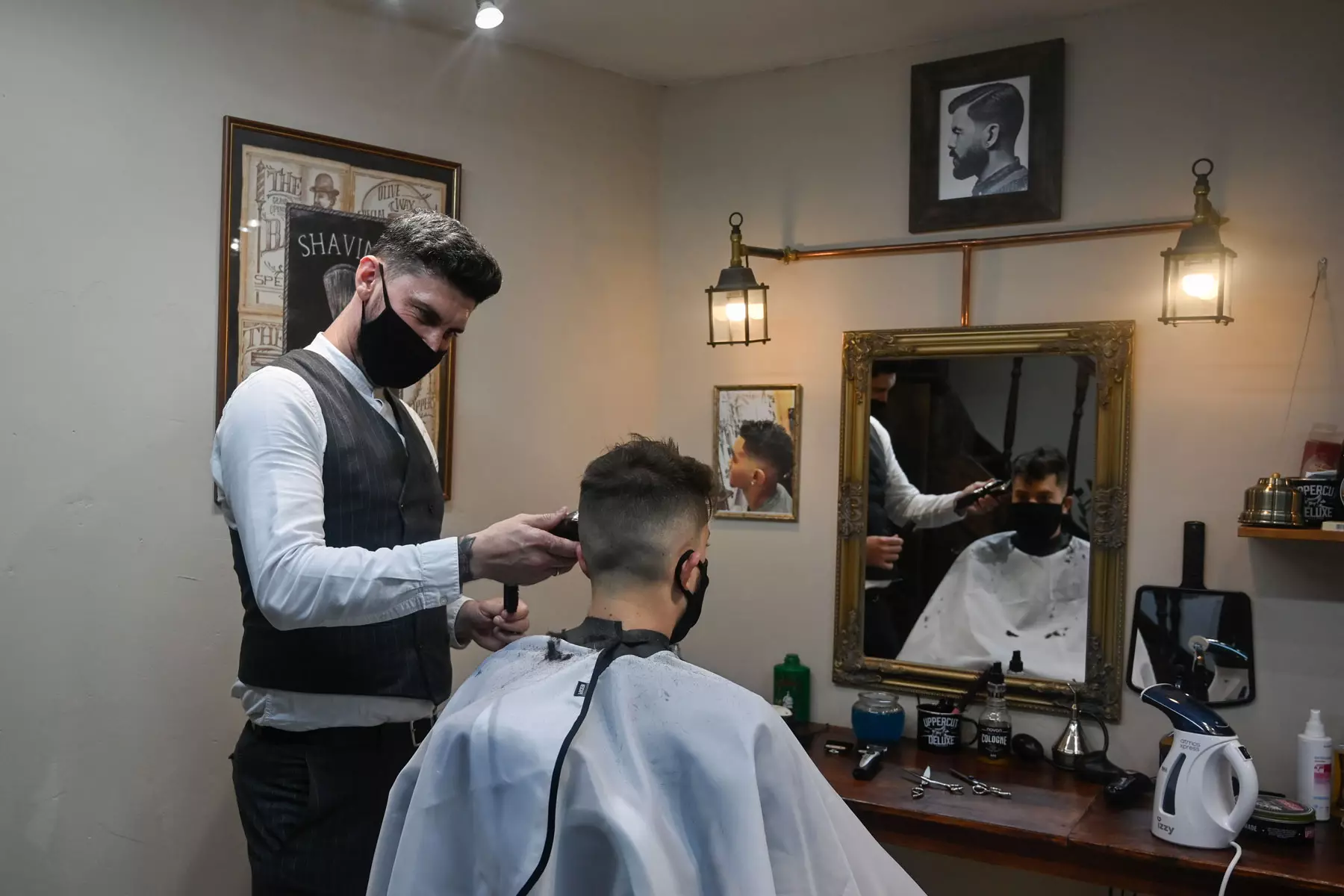 hommes dans un salon de coiffure portant des masques faciaux