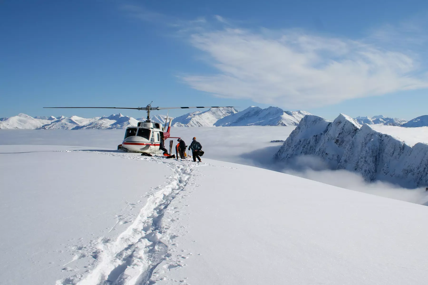 Cov neeg caij ski taug kev mus rau Heli-skiing helicopter