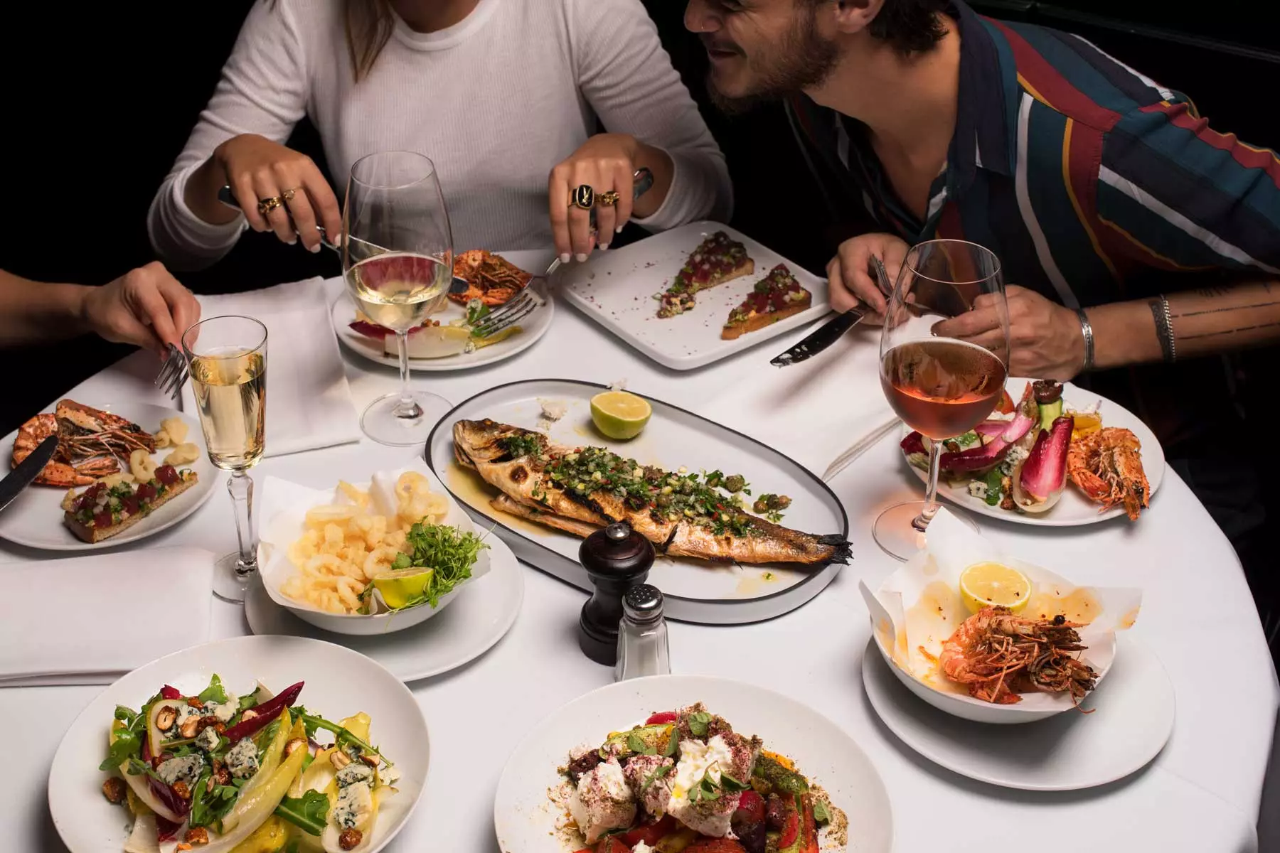 Amis appréciant une variété de plats méditerranéens dans un restaurant