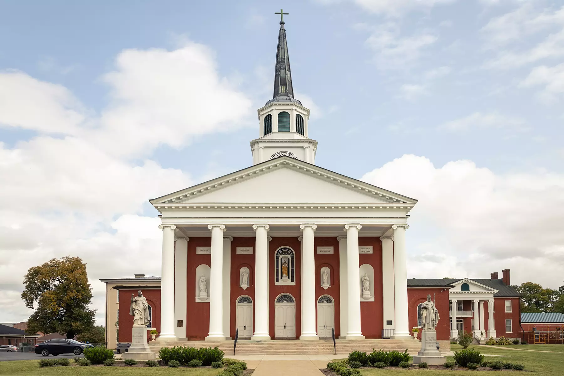 Католическая церковь в Бардстауне, штат Кентукки, построена из красного кирпича с высоким белым шпилем и колоннами.