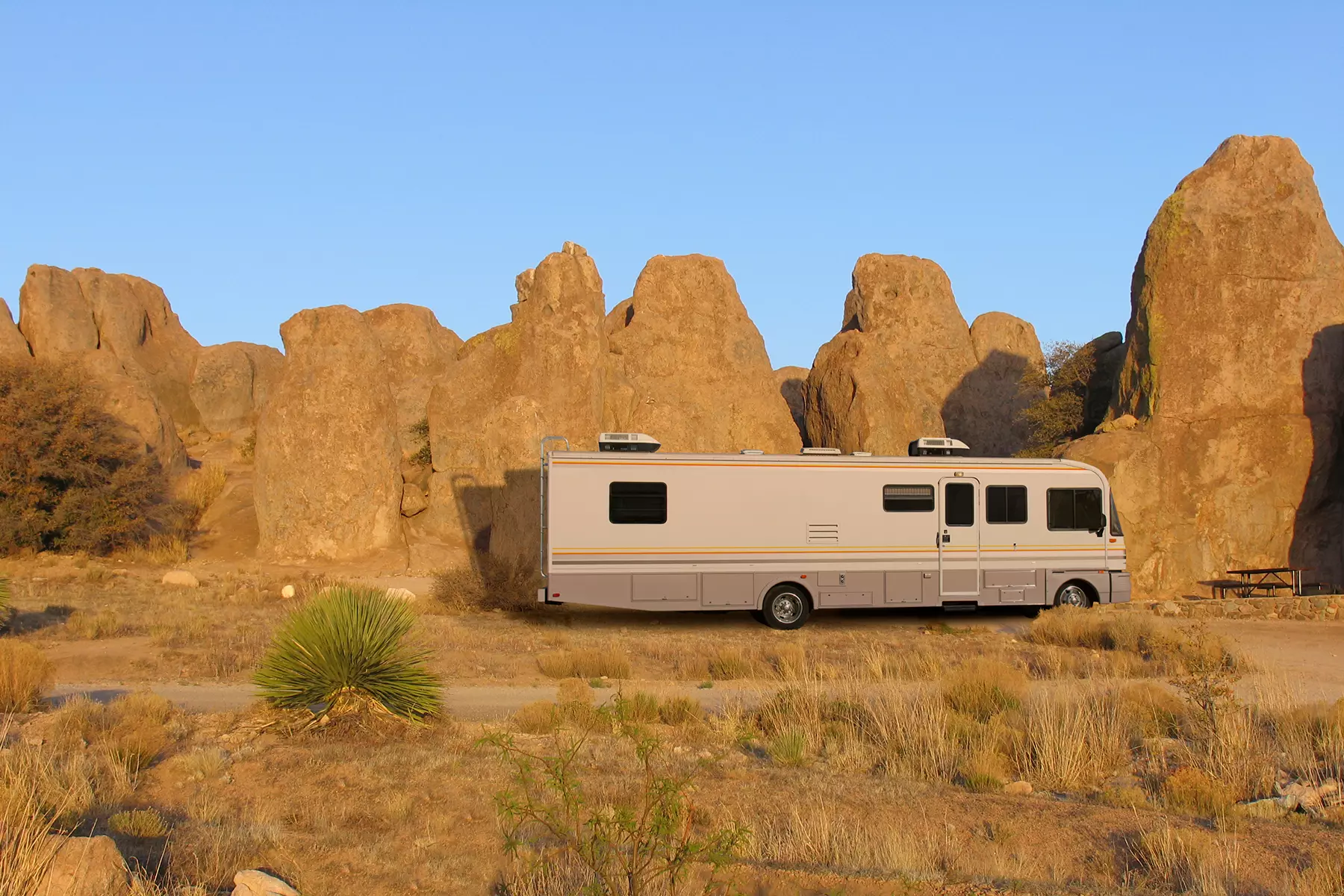 Cartref modur dosbarth wedi'i barcio mewn maes gwersylla ym Mharc Talaith City of Rocks ger Deming, New Mexico, UDA