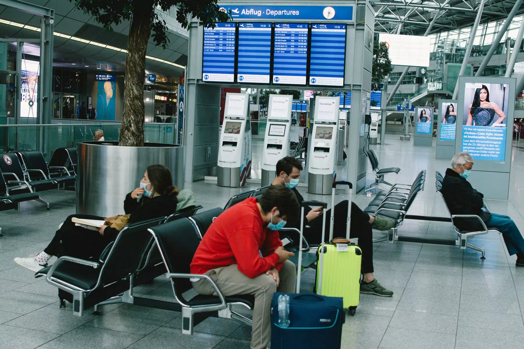 Människor som bär masker väntar på flygplatsen