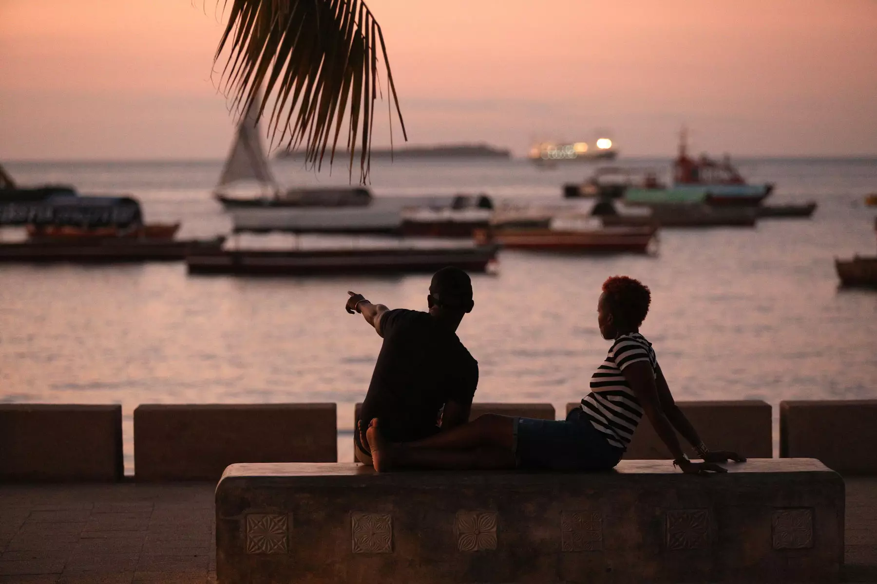 twee mense kyk na 'n sonsondergang in Zanzibar