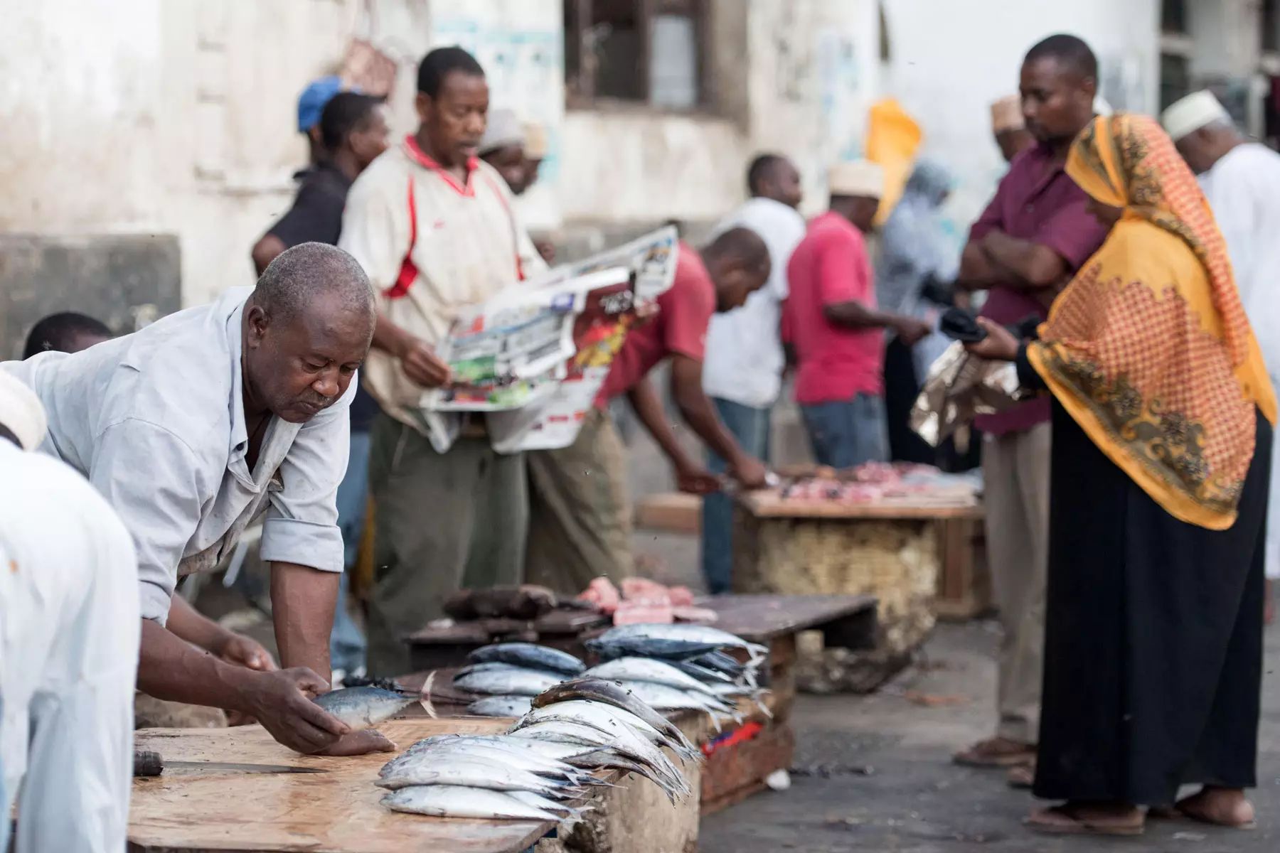 O lo'o fa'atali se tagata fa'atau i'a mo tagata fa'atau i se maketi i Stone Town.