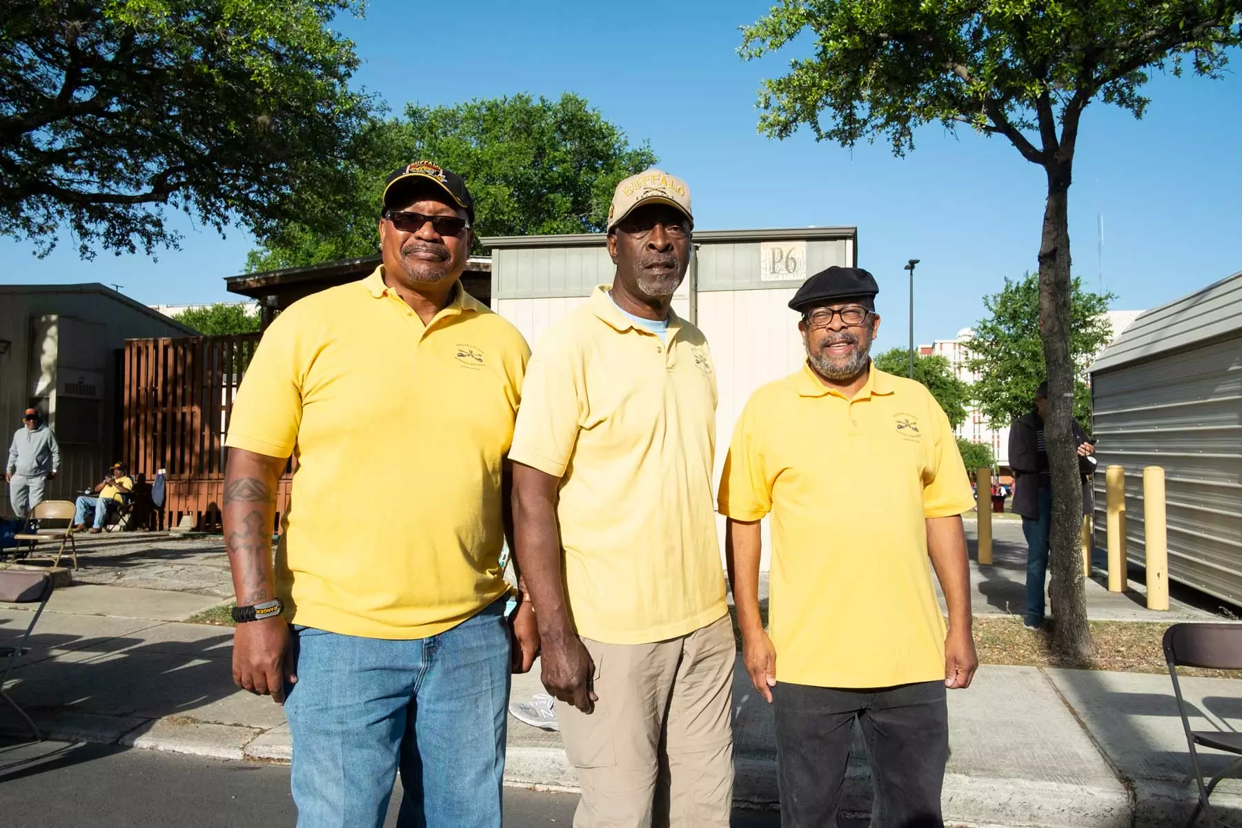 Soldados de búfalo del condado de Bexar con camisas amarillas, presentando una sección de asientos para el Desfile de la Batalla de las Flores en San Antonio, Texas.