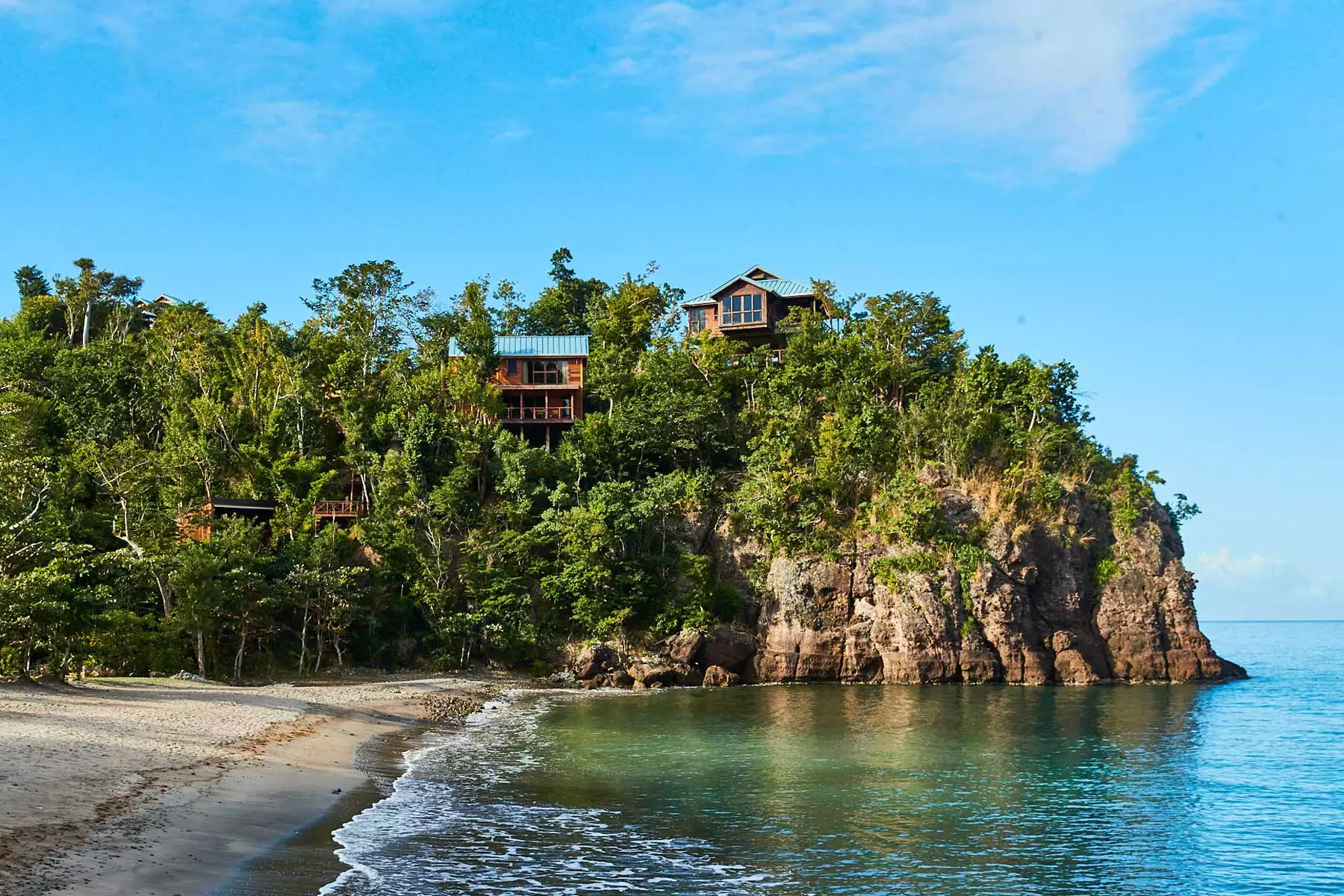 Indawo Yokungcebeleka Engcono Kakhulu e-Caribbean, okuhlanganisa i-Secret Bay, e-Dominica, enezindlu zokuhlala ezibekwe egqumeni eliluhlaza.