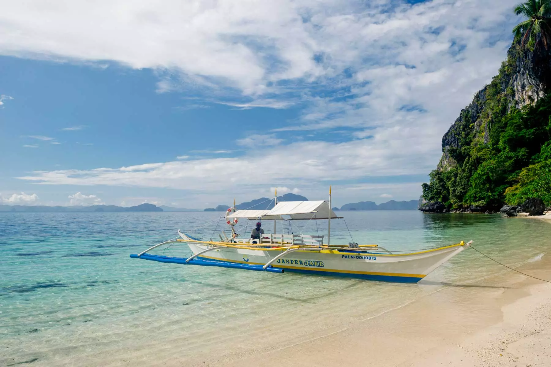 Bangka-Auslegerboot, Pumpboot, vor Anker an einem weißen Sandstrand während einer Schnorcheltour beim Inselhüpfen von El Nido zum Bacuit-Archipel, Insel Palawan.