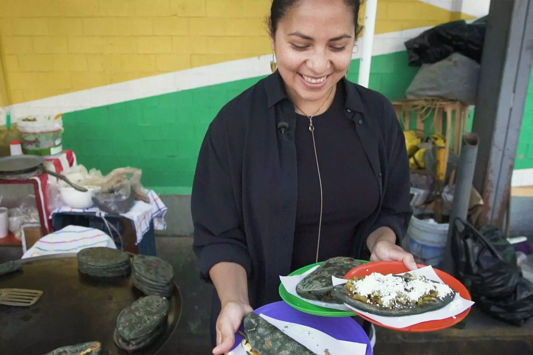 Anais Martinez drži tanjire meksičke ulične hrane u svojoj epizodi Walk With T+L