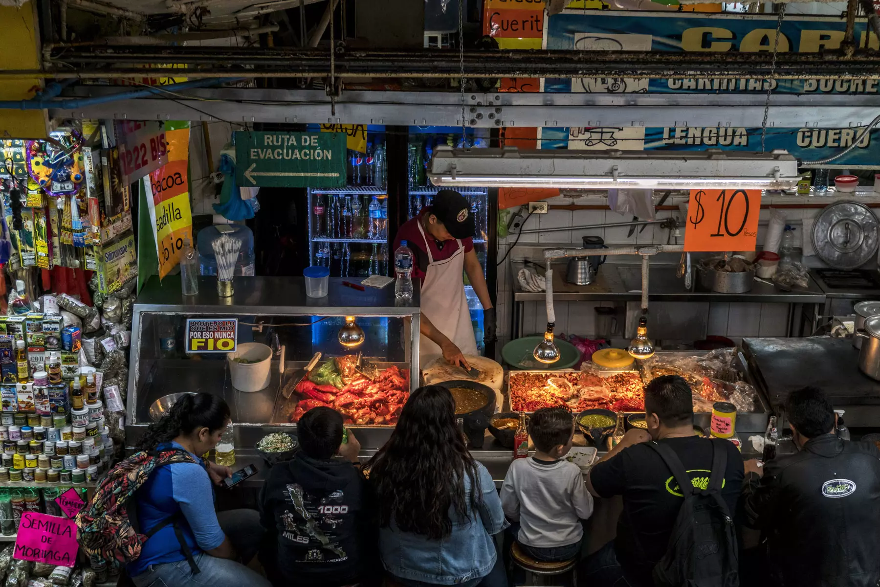 Kupci jedu na štandu s hranom u Mercado San Juan de Dios.