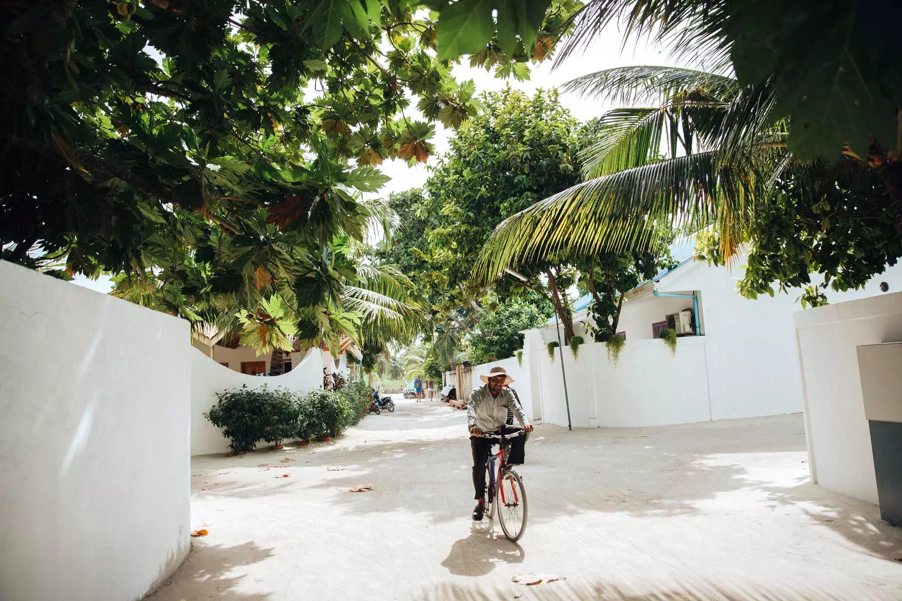 Burri duke ngarë biçikletën në rrugë në ishullin Ukulhas, Maldive.