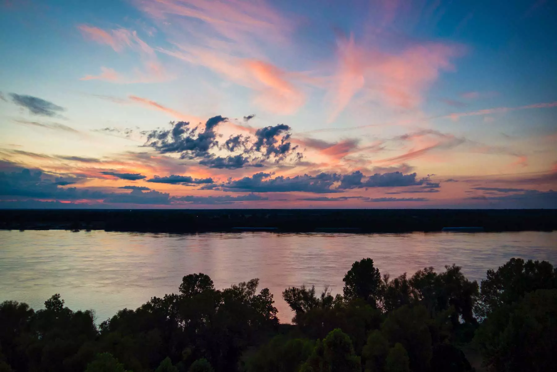 Įspūdingas saulėlydis virš Misisipės upės netoli Natchez su debesimis ir atspindžiais vandenyje