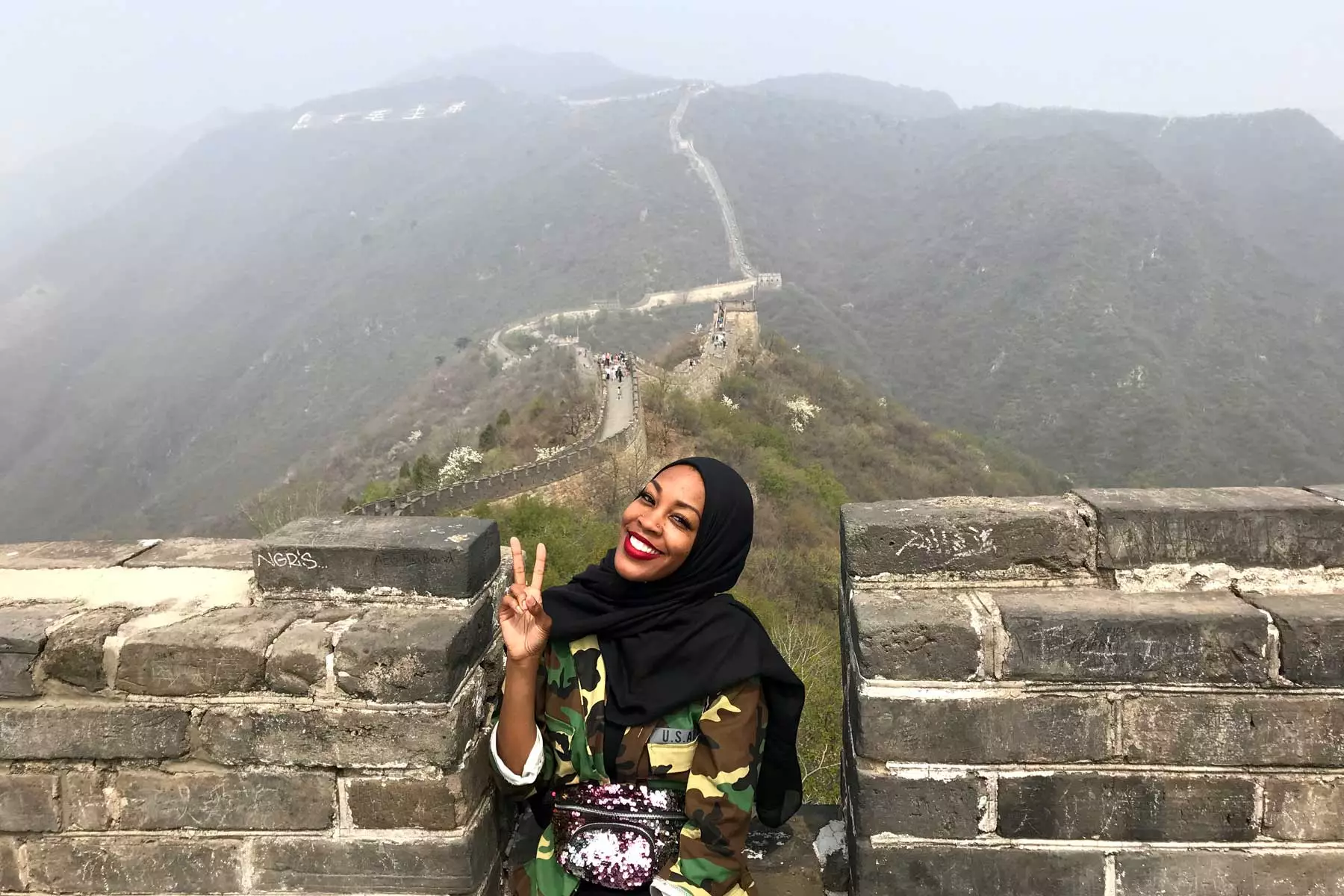 Imani Bashir poseert op de Chinese Muur