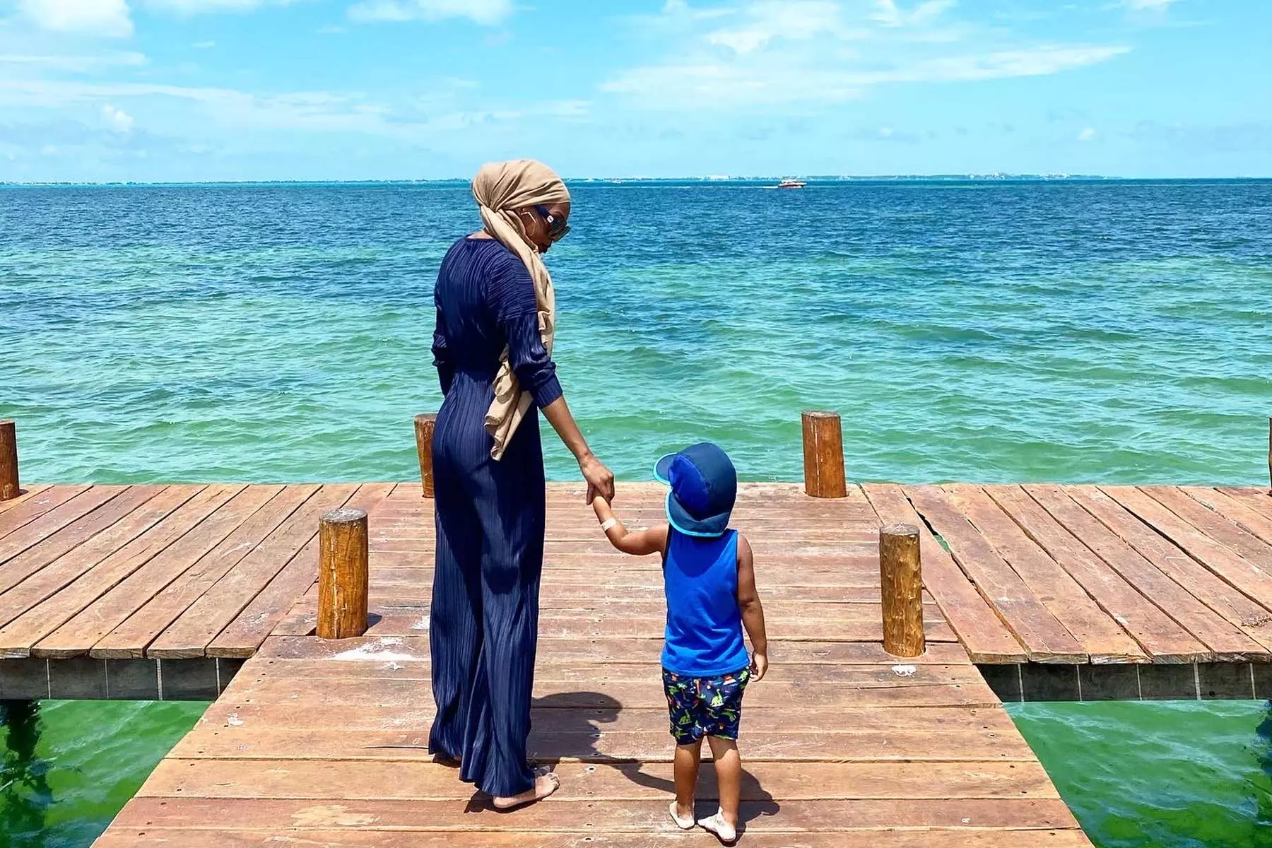 Imani Bashir en haar zoon lopen over het dok in de oceaan