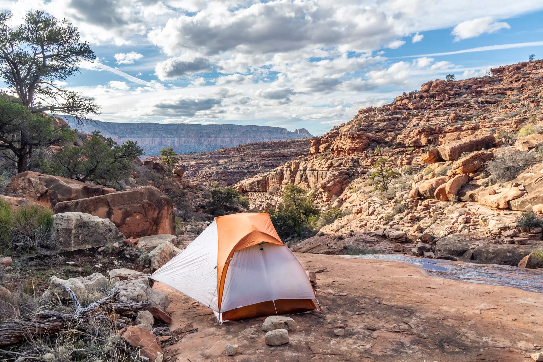 Zango a kan wani dandali na dutse a cikin Royal Arch magudanun ruwa, ruwa mai gudana a kusa, Grand Canyon National Park, Arizona