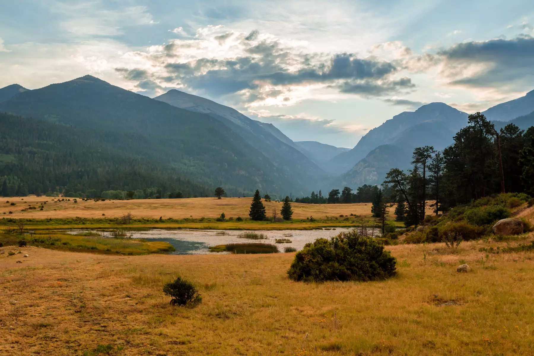 Imibala yokushona kwelanga esibhakabhakeni phezu kwechibi lezimvu nokhahlamba lwezintaba e-Rocky Mountain National Park