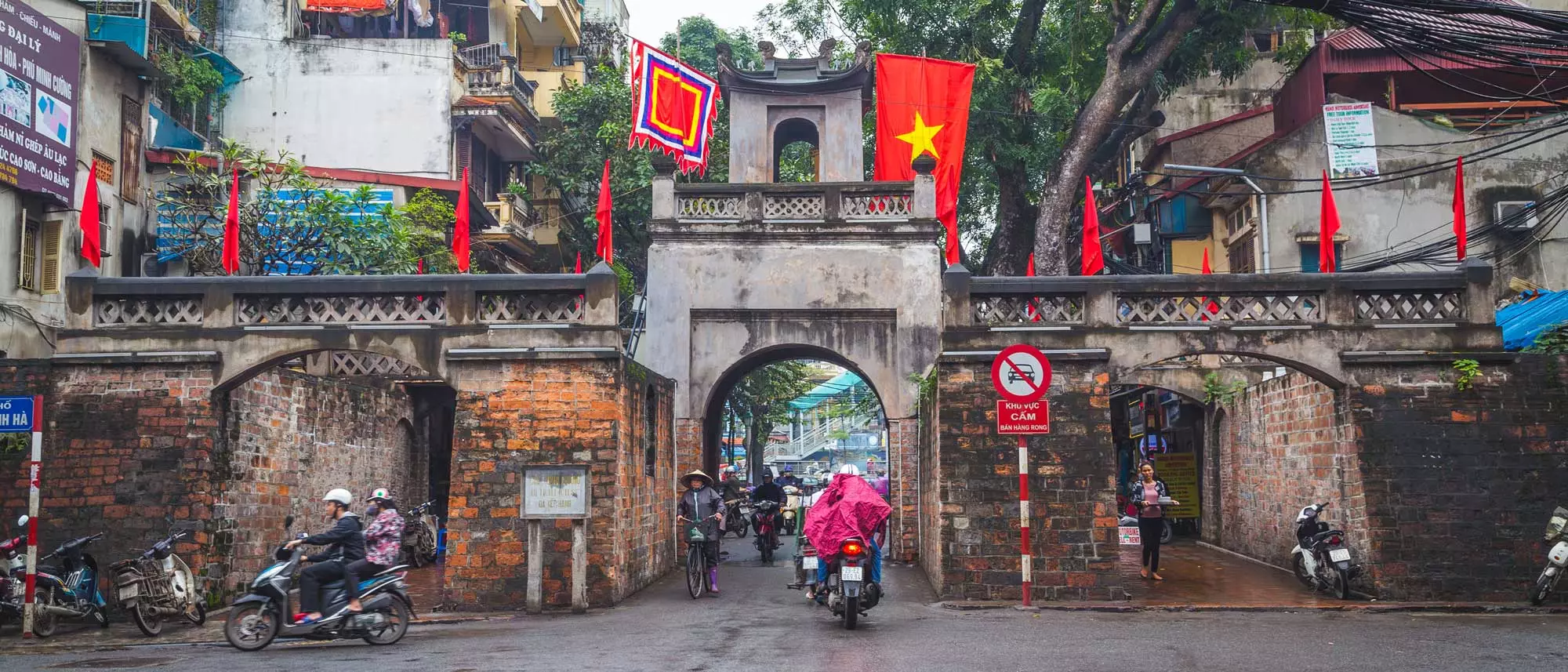 Mestna vrata Quan Chuong v stari četrti Hanoja podnevi. Ljudje se vidijo.