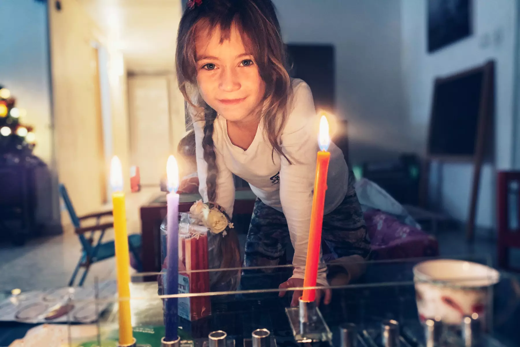 Mtsikana wamng'ono akuyatsa menorah kunyumba