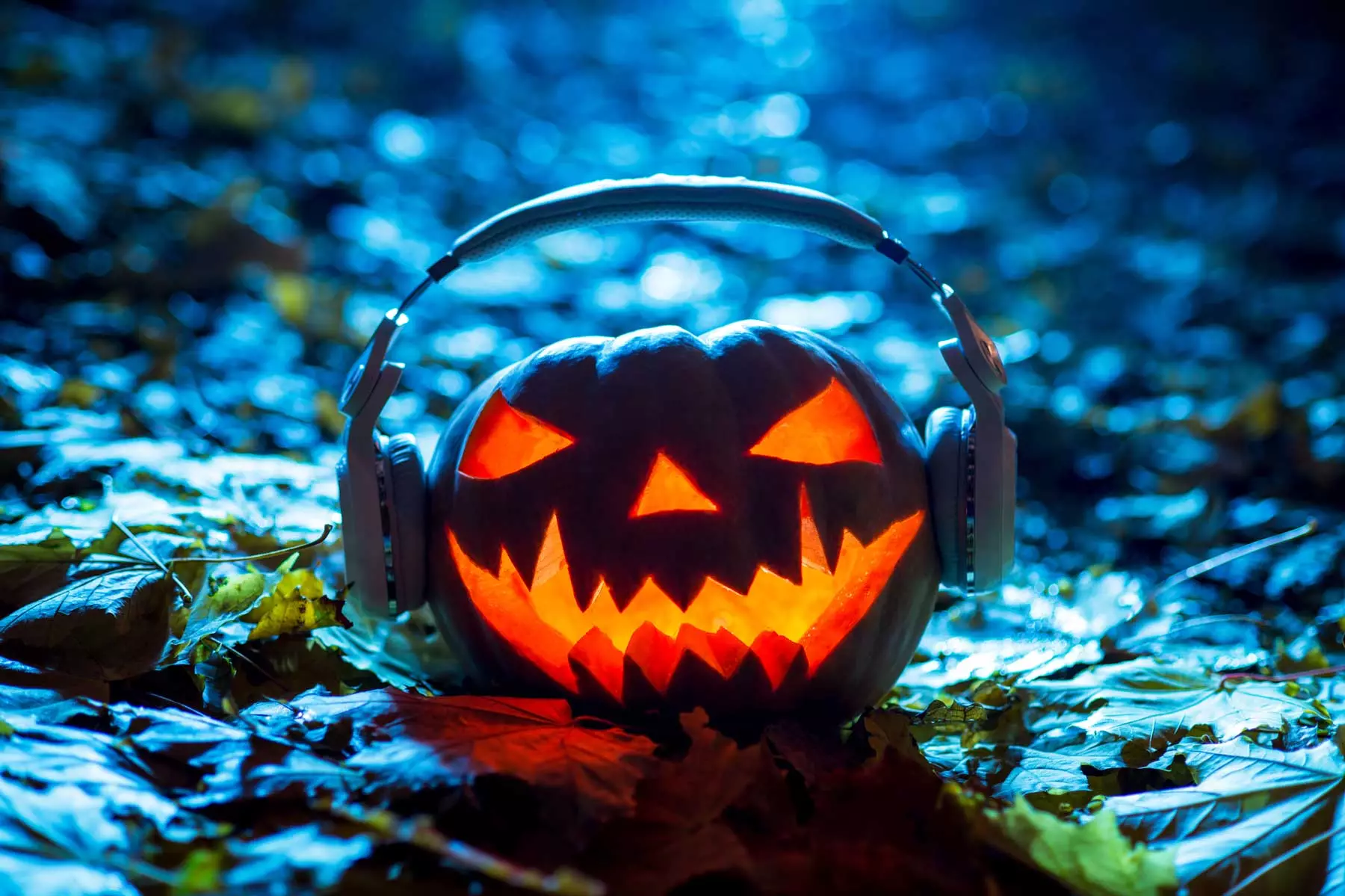 Jack-o-lantern ithanga elikhazimlayo kunye headphones kwihlathi ekwindla ebusuku