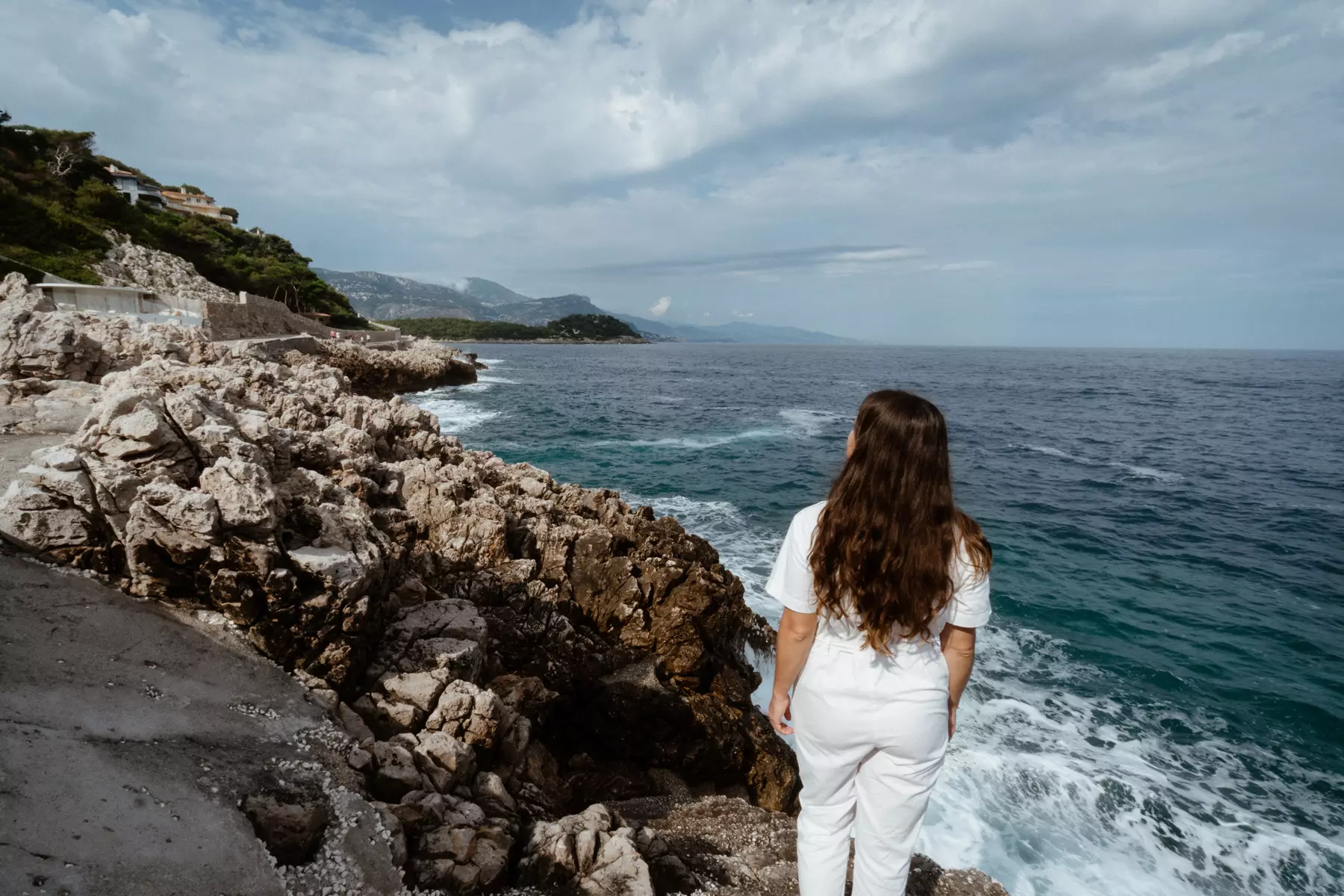 Mujer mira el océano a lo largo de la costa francesa