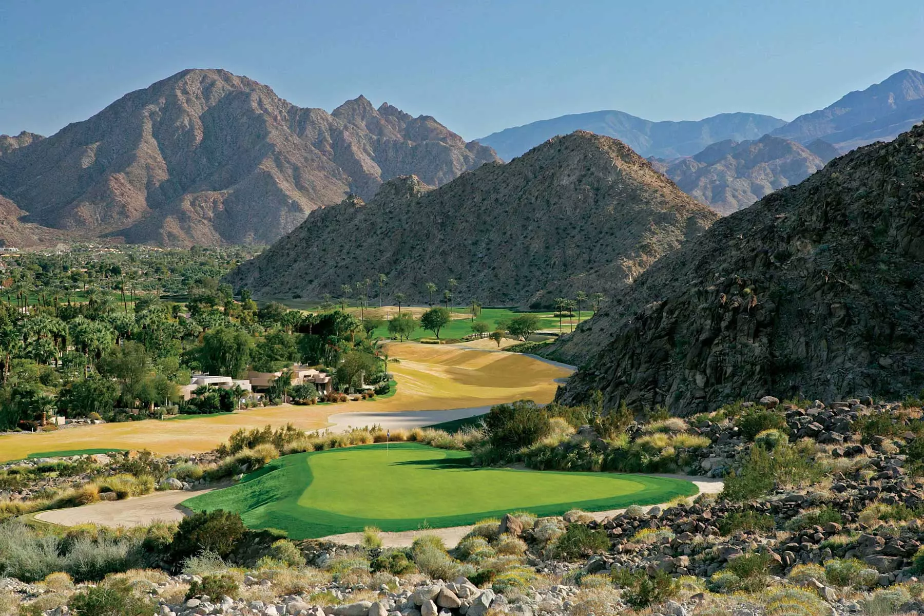 Radharc ar chúrsa gailf agus sléibhte i bhfad i gcéin ag La Quinta Resort & Club i Palm Springs, California