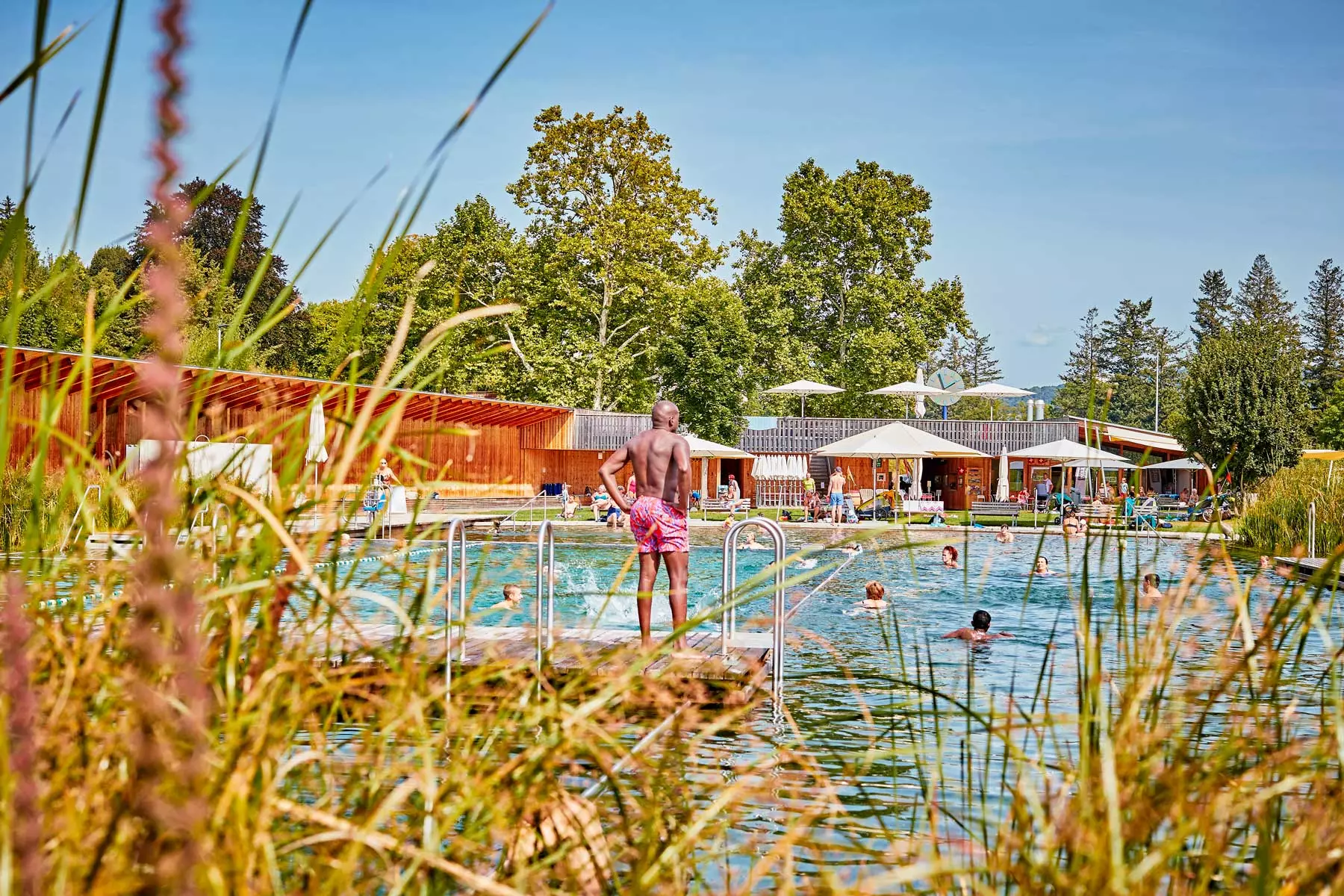 Isang lalaking nakatayo sa tabi ng pampublikong pool sa Switzerland