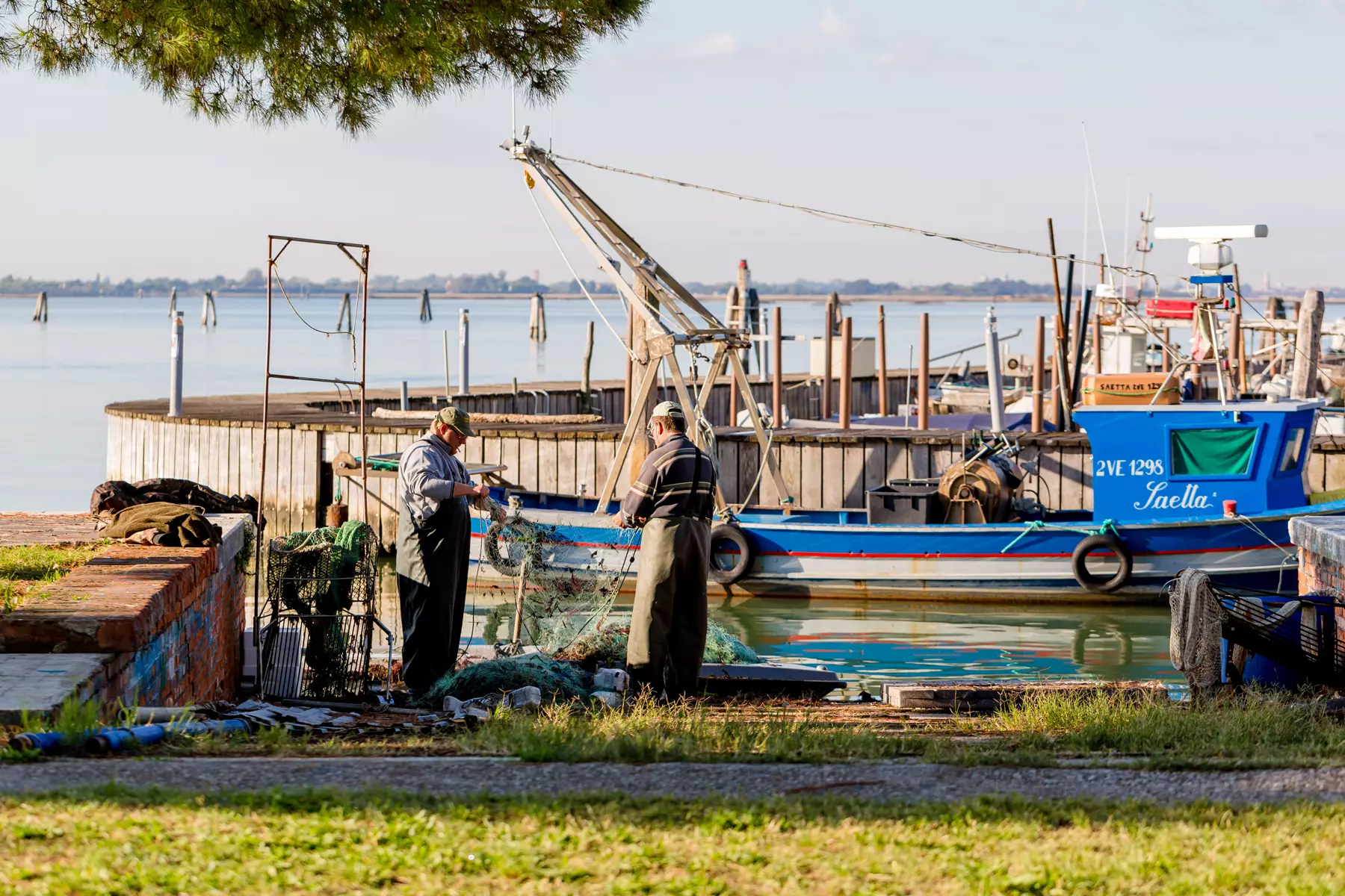 Italiýanyň Burano şäherinde işleýän balykçylar