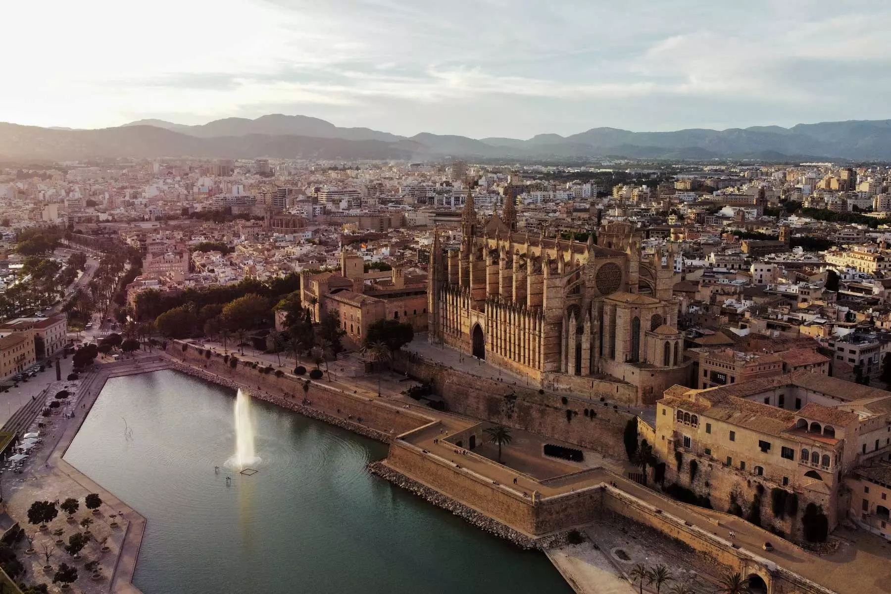 Panoráma města Palma de Mallorca s katedrálou a fontánou, letecký pohled při západu slunce