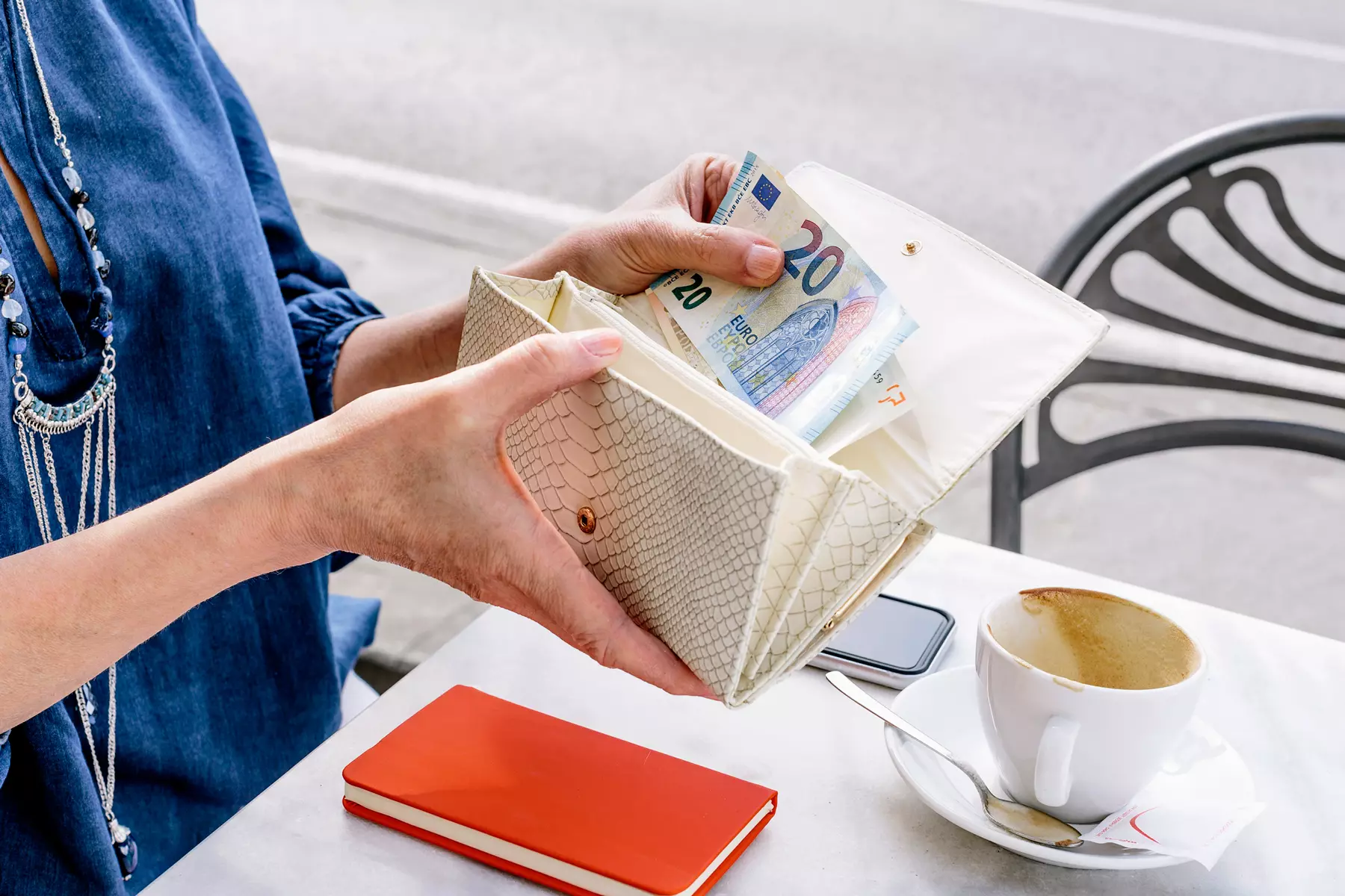 Mano de mujer madura quitando el billete del monedero en la cafetería, Fiesole, Toscana, Italia