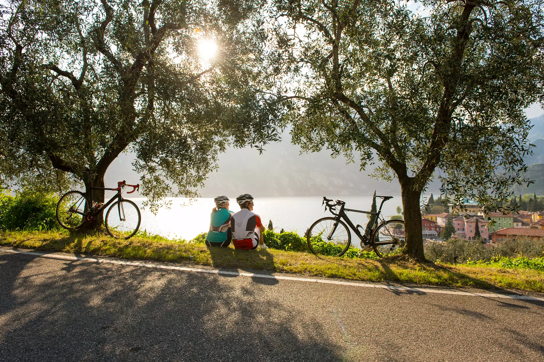 Pareja tomando un descanso en bicicleta al amanecer en el lago de Garda en Italia