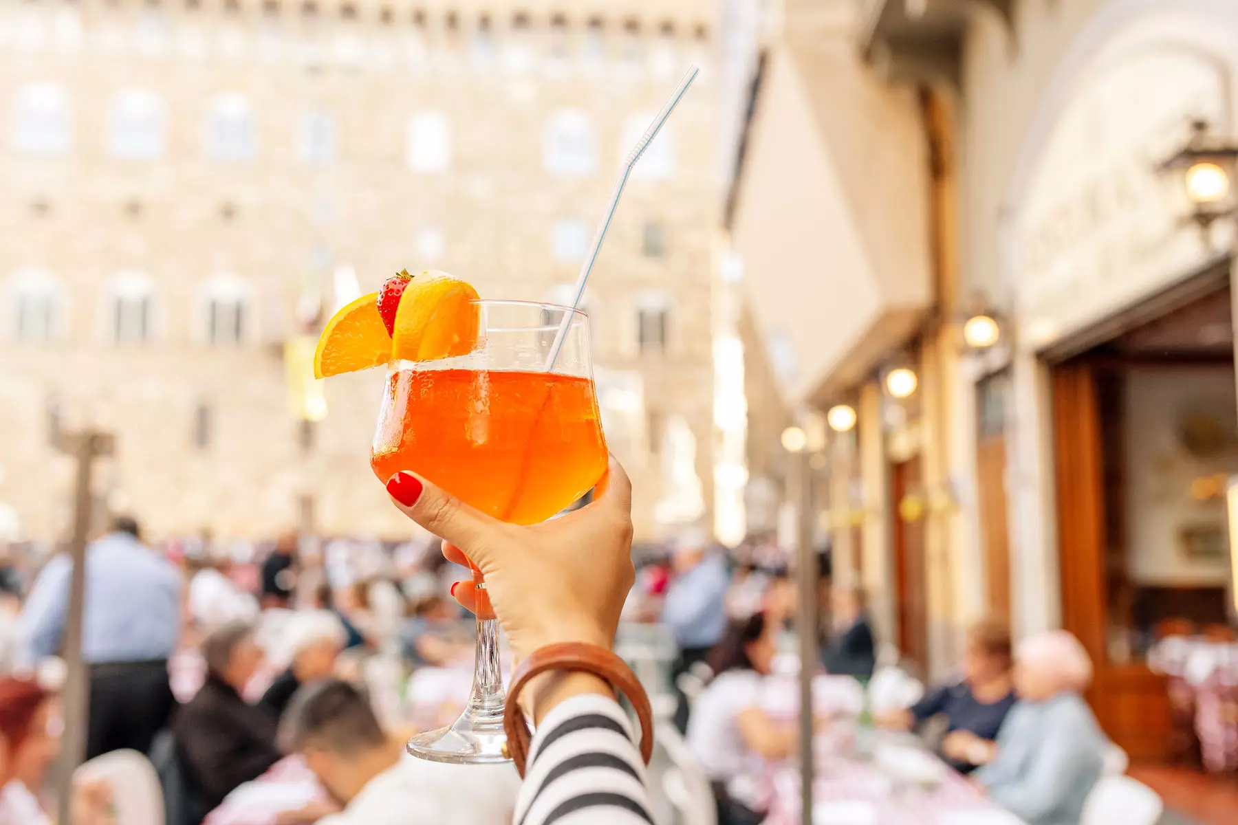 Mujer sosteniendo Aperol Spritz en Italia