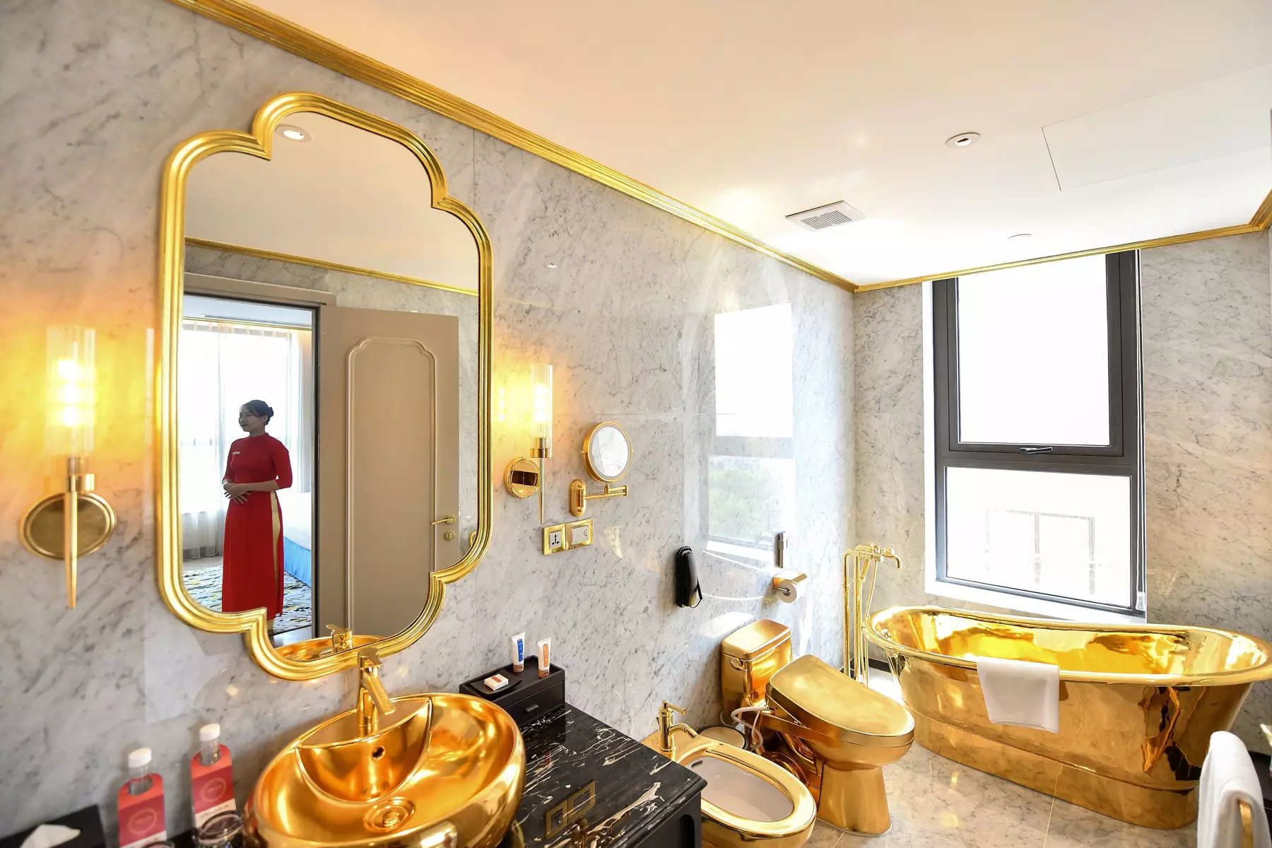 Član osoblja pozira za fotografiju unutar 1000 USD po noći izvršnog apartmana s dvije spavaće sobe u novootvorenom hotelu Dolce Hanoi Golden Lake