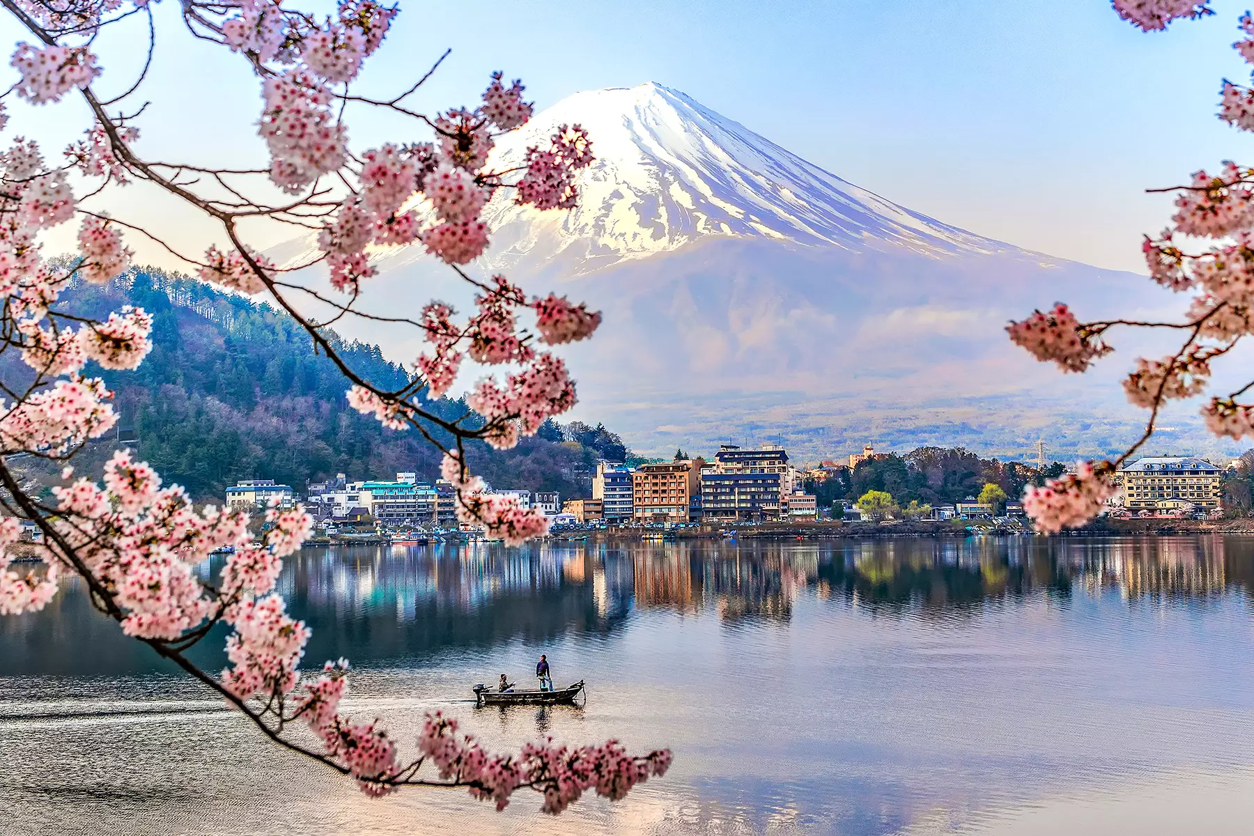 Onye na-akụ azụ̀ na-akwọ ụgbọ mmiri na Kawaguchiko Lake na Sakura na Fuji Mountain Reflection Background